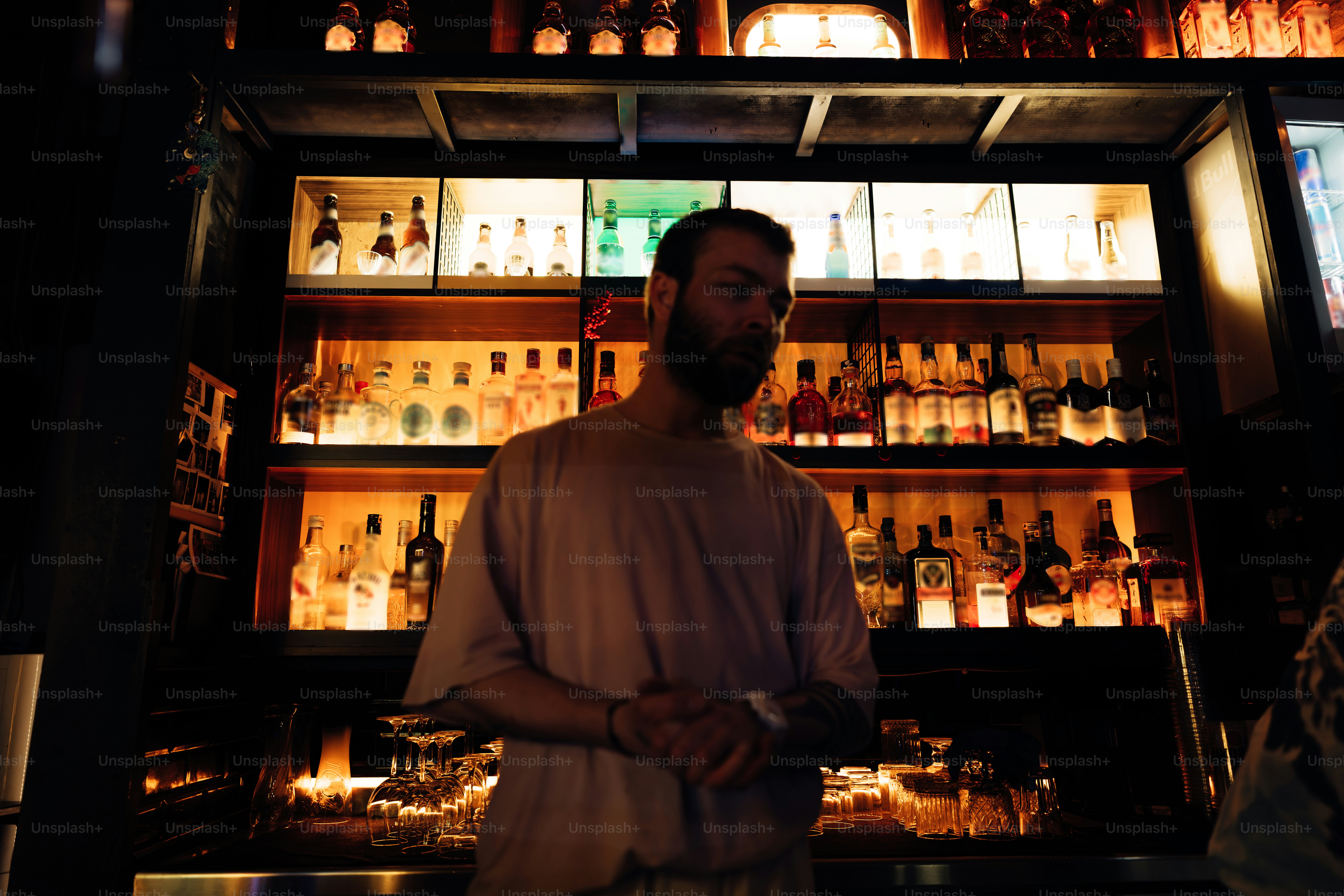 A bartender stands in front of a well-stocked bar. photo – Bar Image on ...