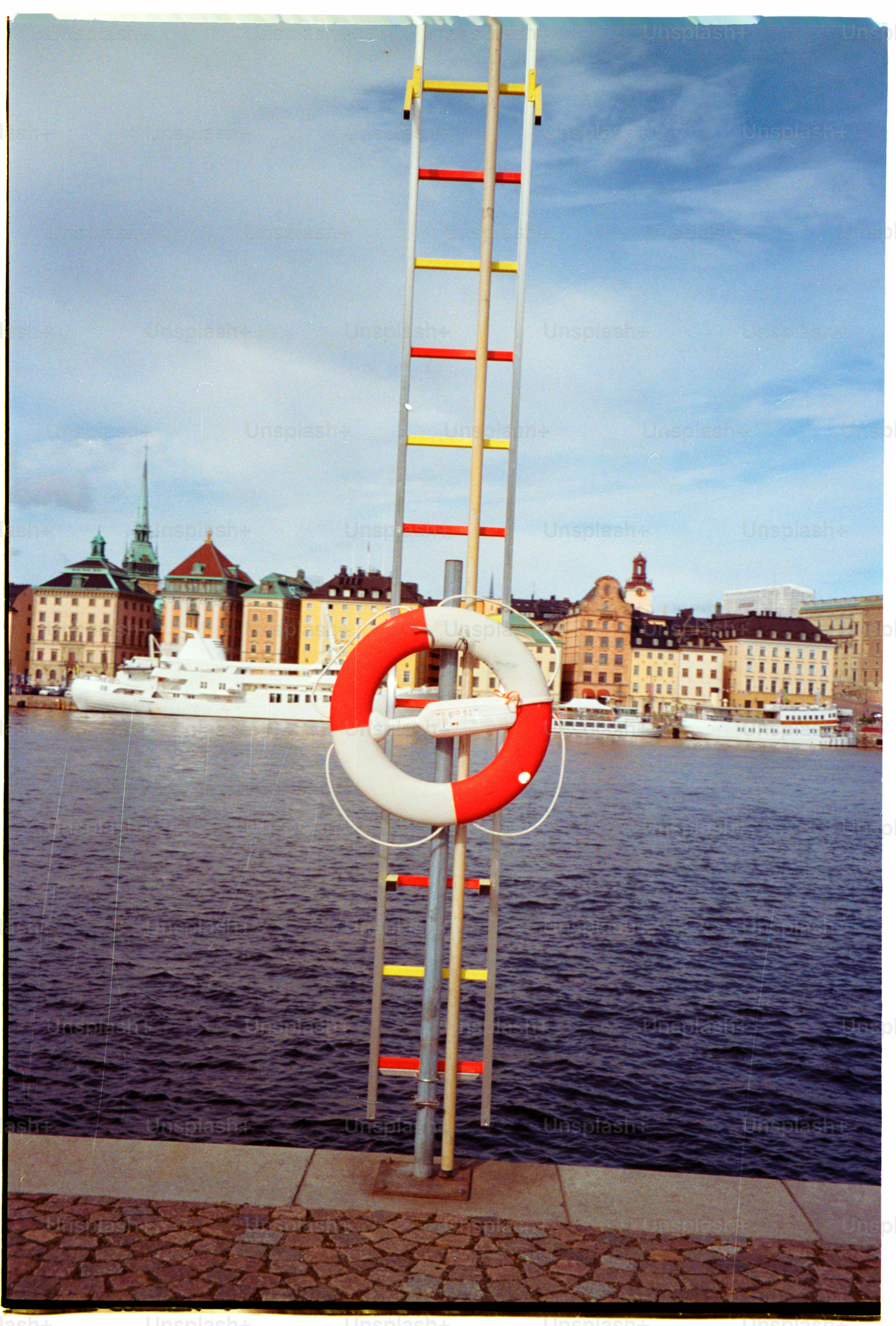 Life preserver and ladder stand near water. photo – Sweden Image on ...