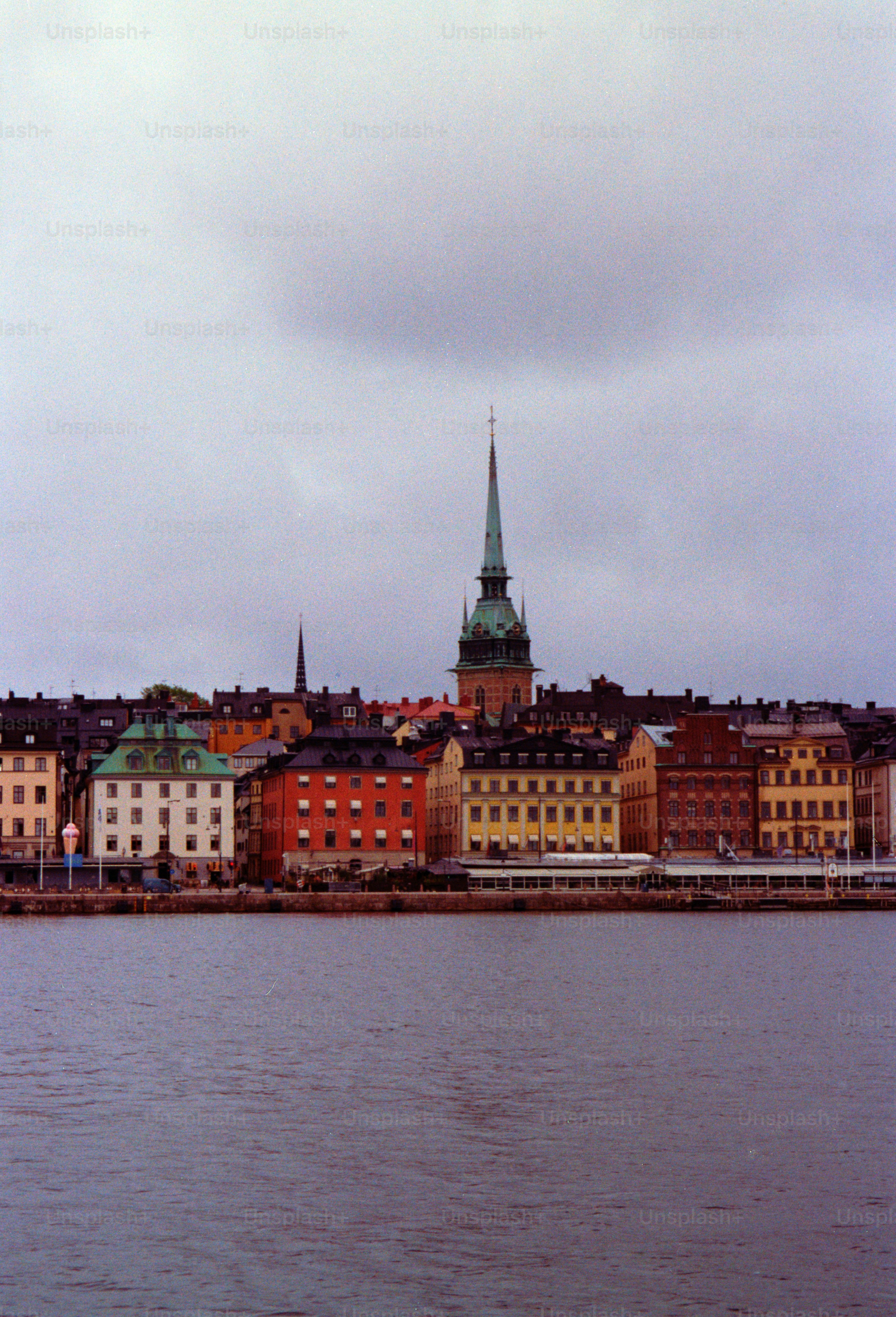 Cityscape with church spire seen over water. photo – Sweden Image on ...