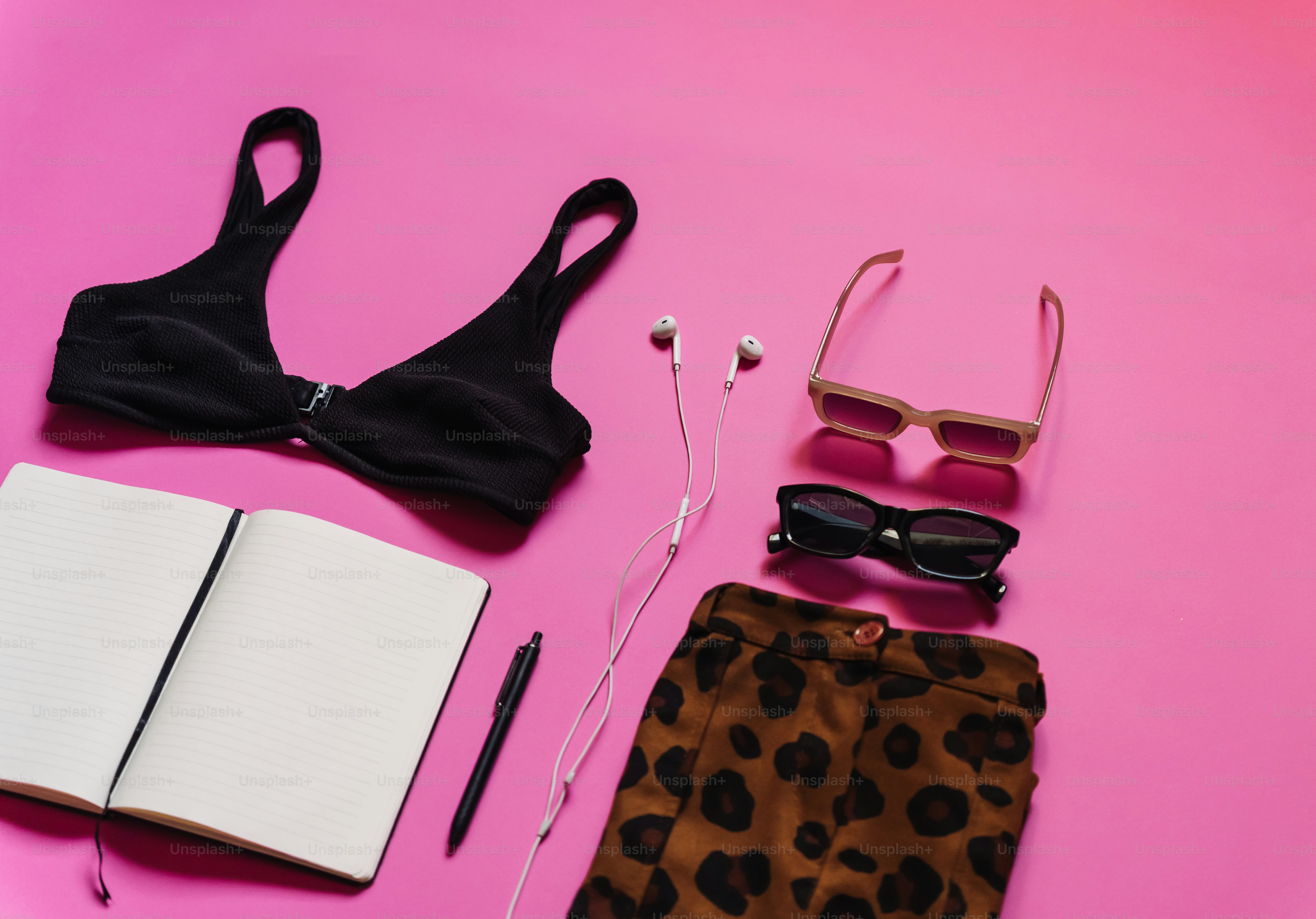 Summer essentials are laid out on a pink surface. photo – Pink ...