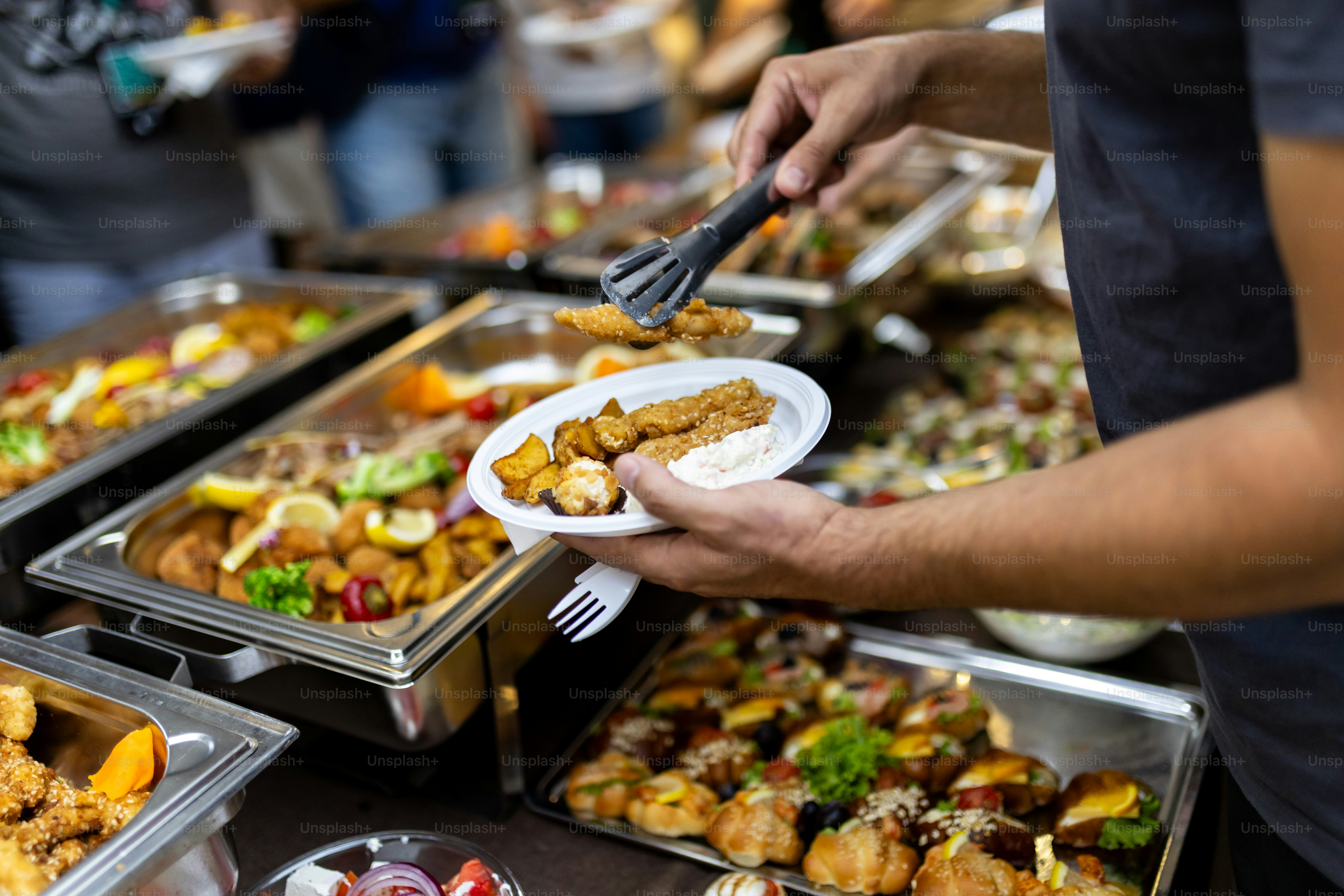 Guests take part in a buffet, selecting various delicious dishes to ...