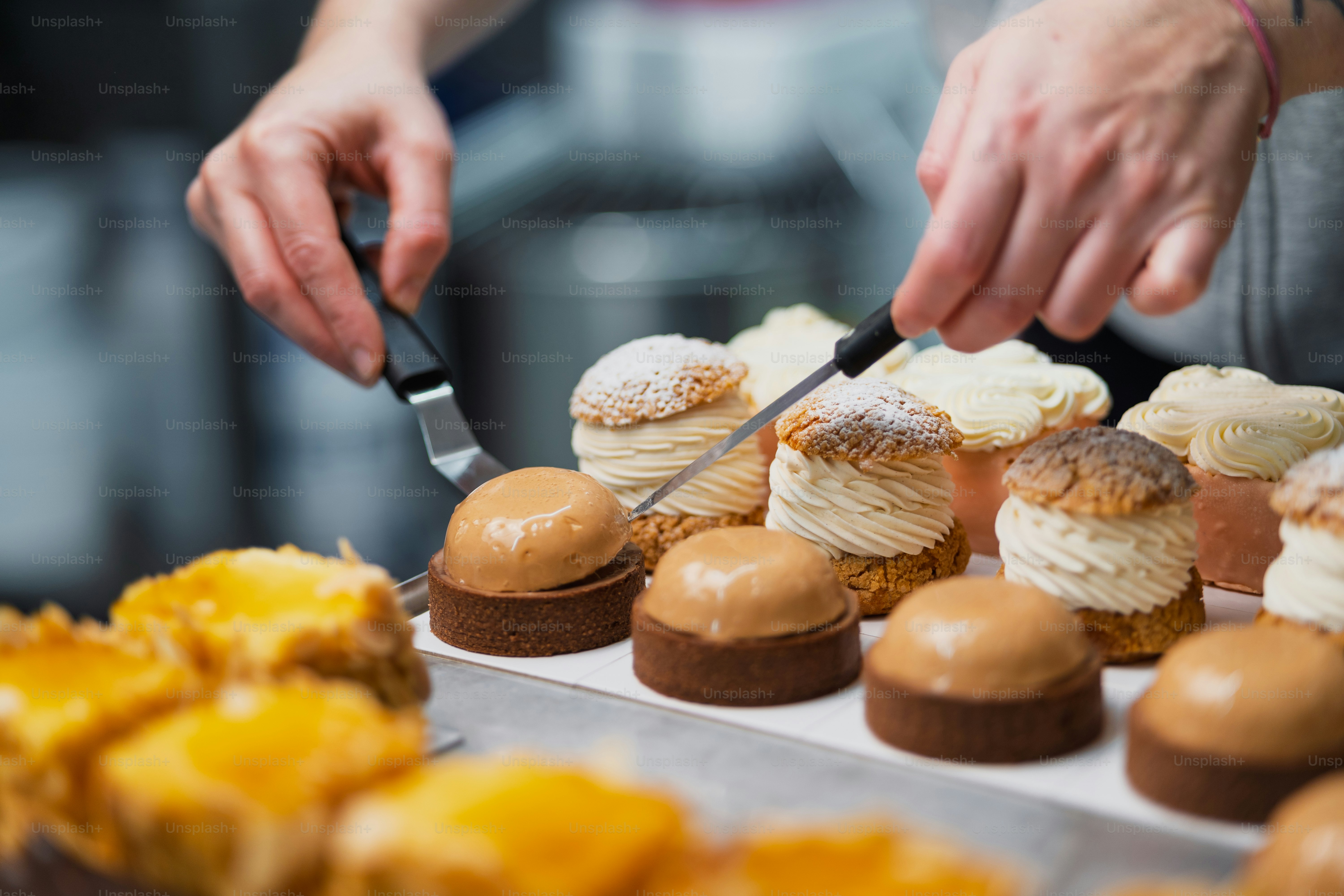 Close-up of a pastry chef's hands meticulously arranging delicious ...