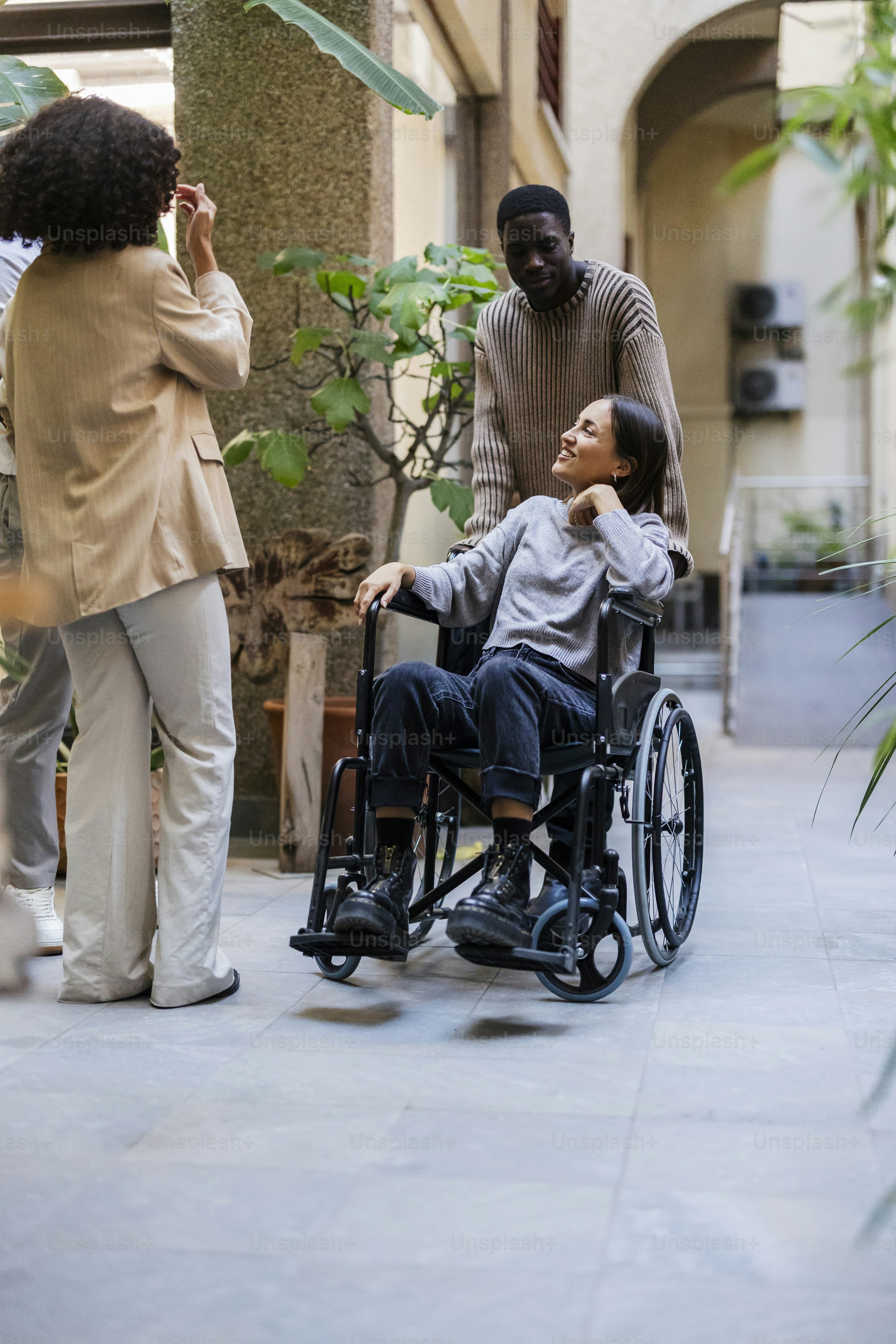 In a light, airy, modern office environment, two colleagues stand ...