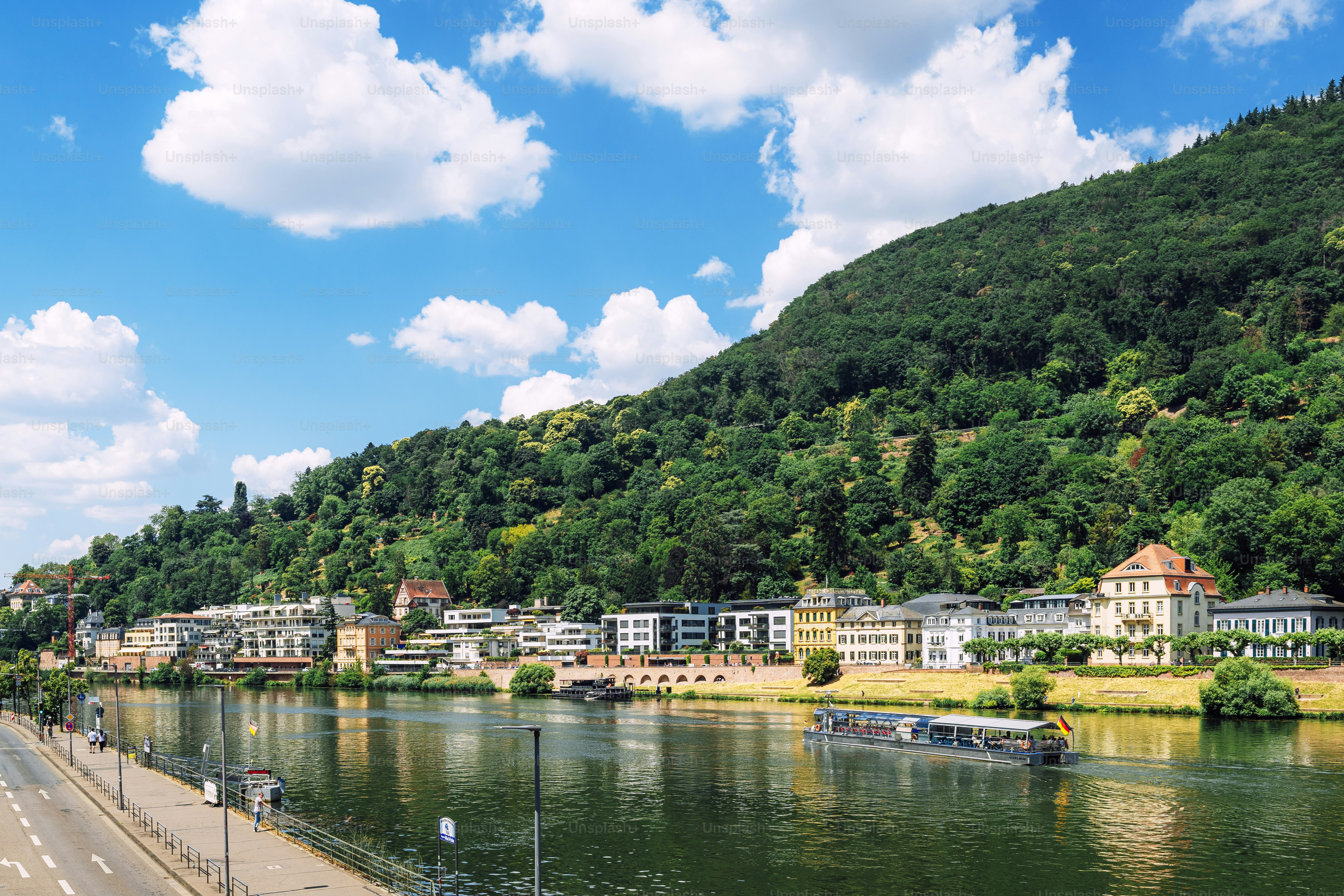 Beautiful riverside scene of Heidelberg, Germany with lush green hills ...