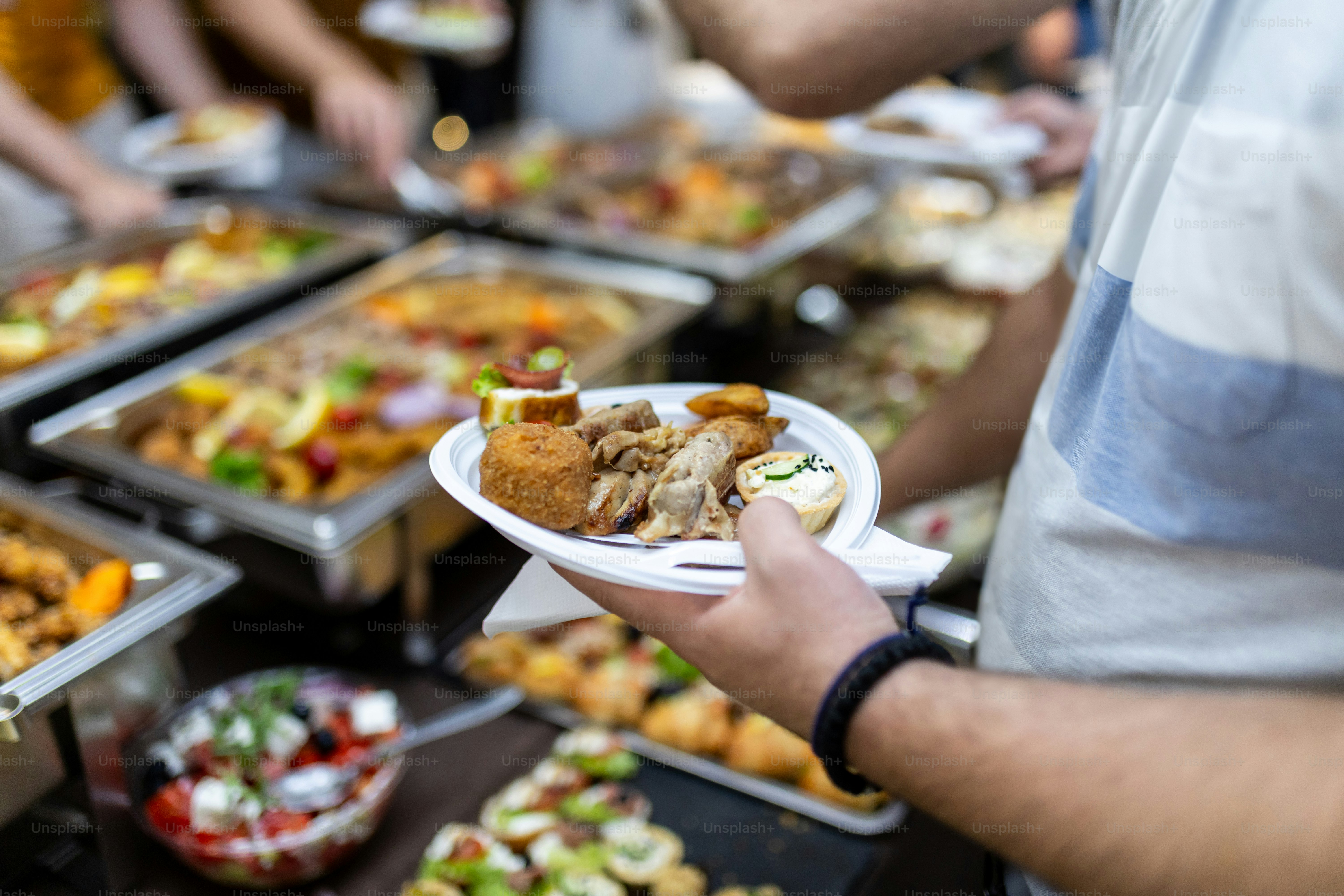 Guests indulge in an array of tasty foods from a buffet, showcasing ...