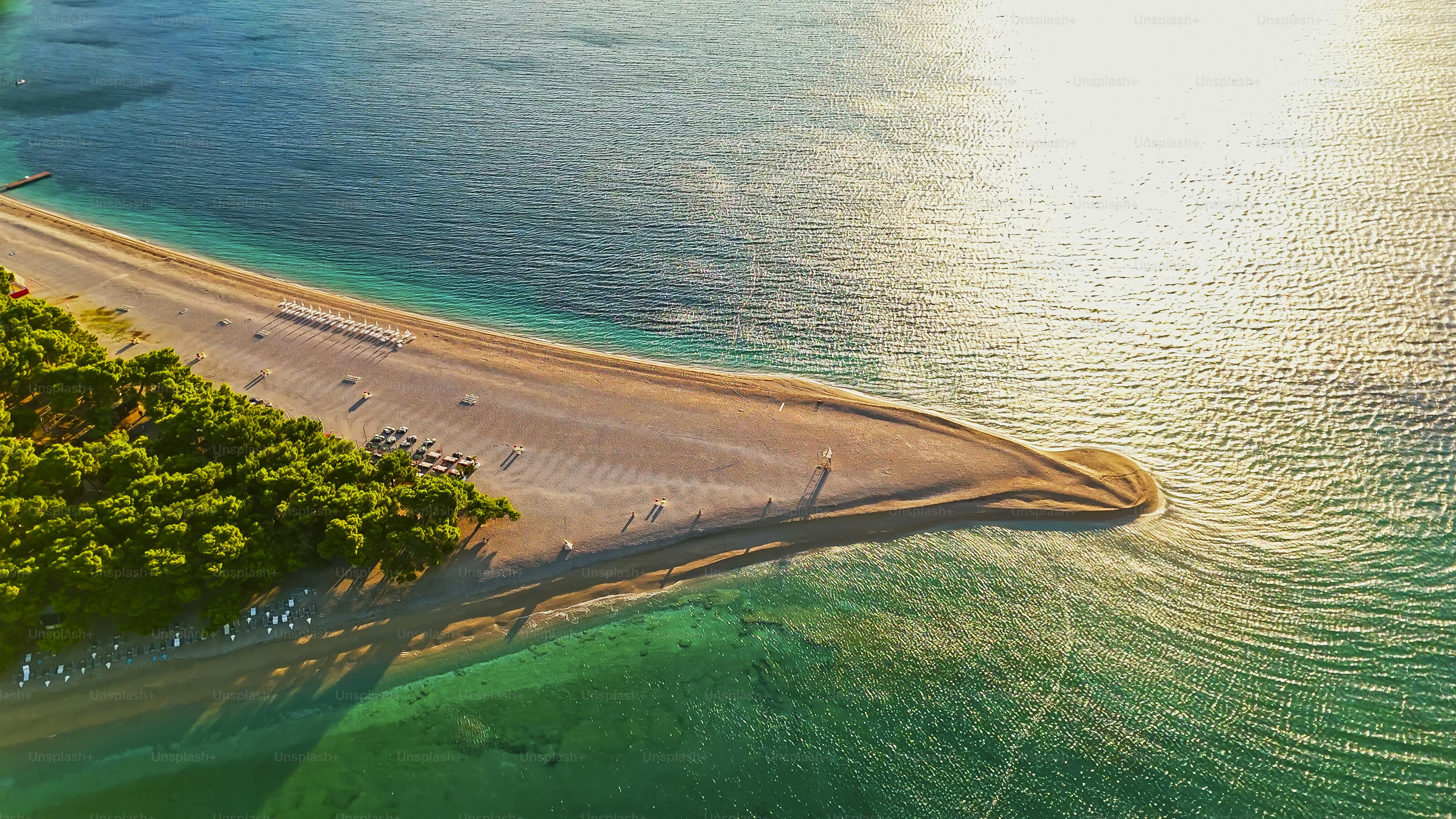 Zlatni Rat beach in Bol at sunrise features golden sands, calm Adriatic ...