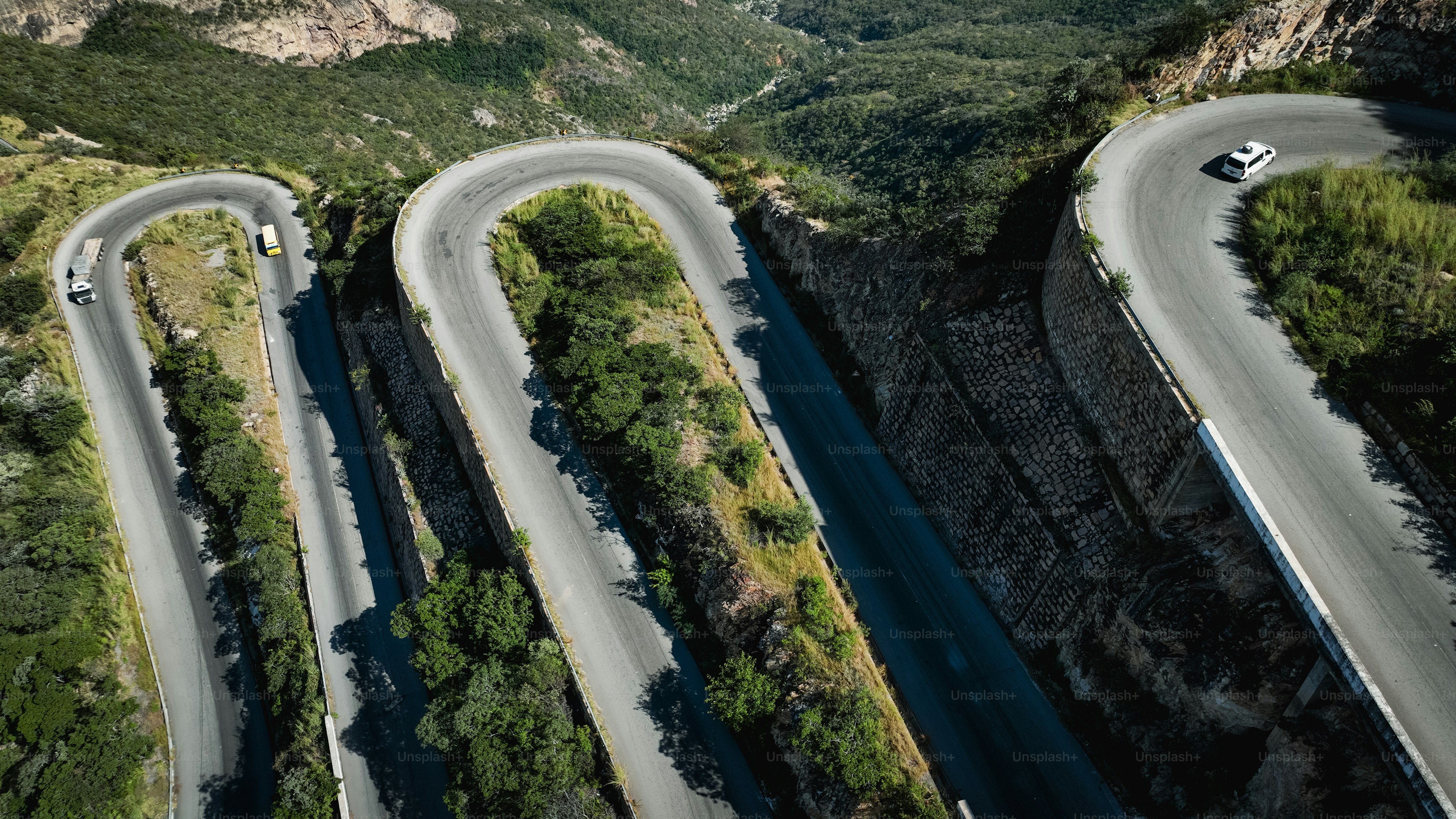 The road snakes through lush green mountains, showcasing the stunning ...