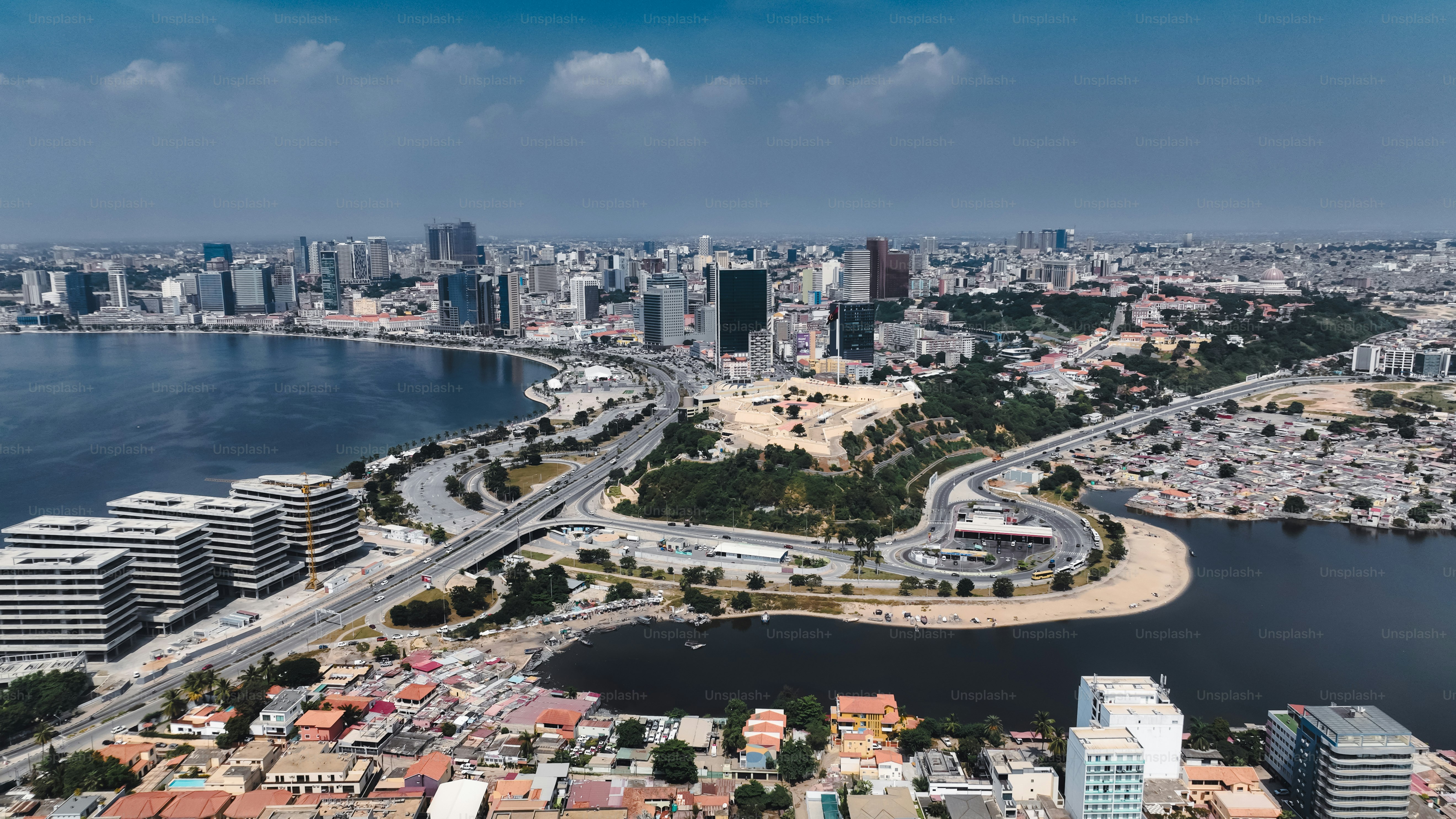 The cityscape of Luanda showcases a blend of modern buildings, coastal areas, and busy streets ...