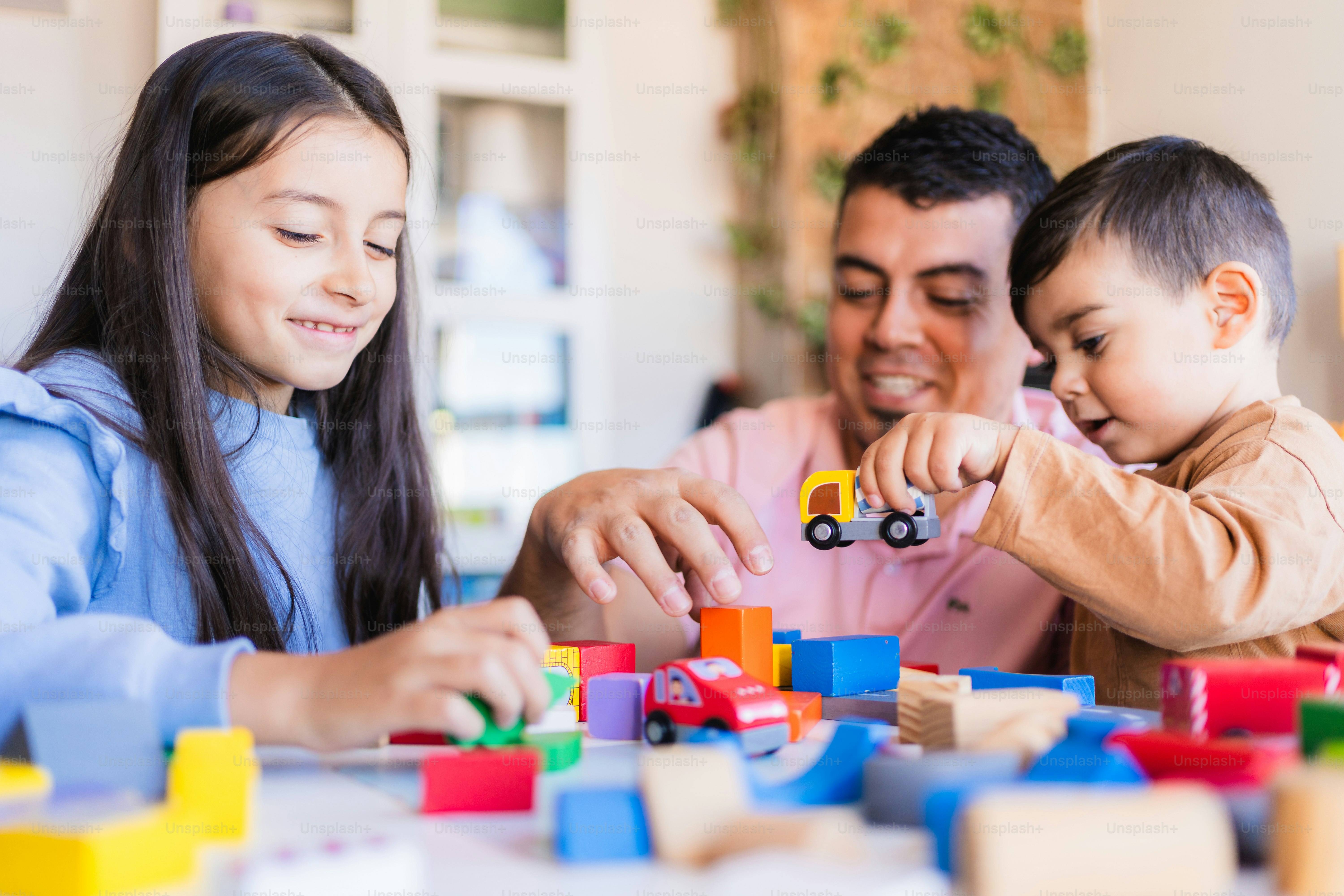 Father and children enjoying playtime together, building and playing ...