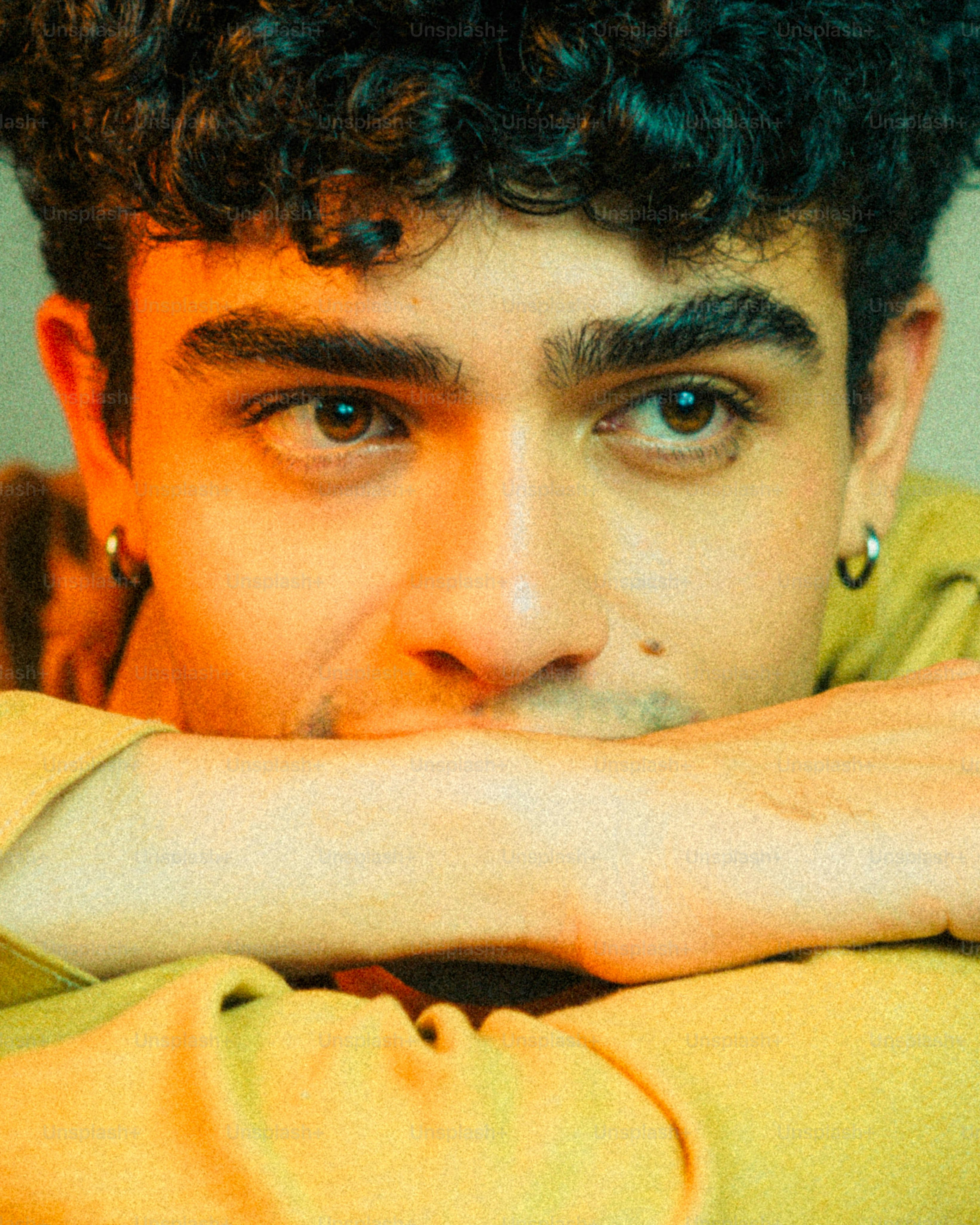 Young man with curly hair resting chin on hands photo – Man Image on ...