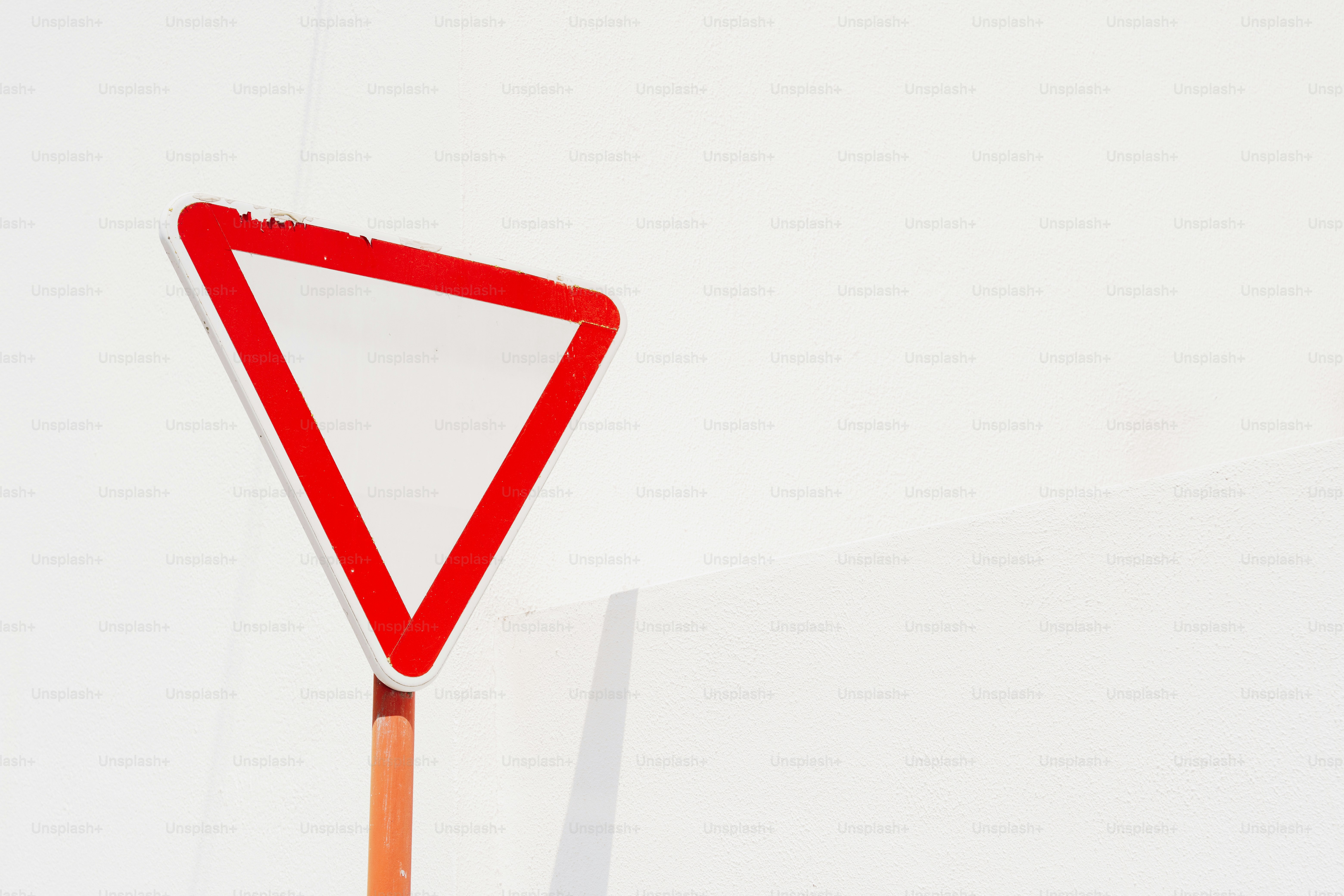 A red and white triangular road sign photo – White Image on Unsplash