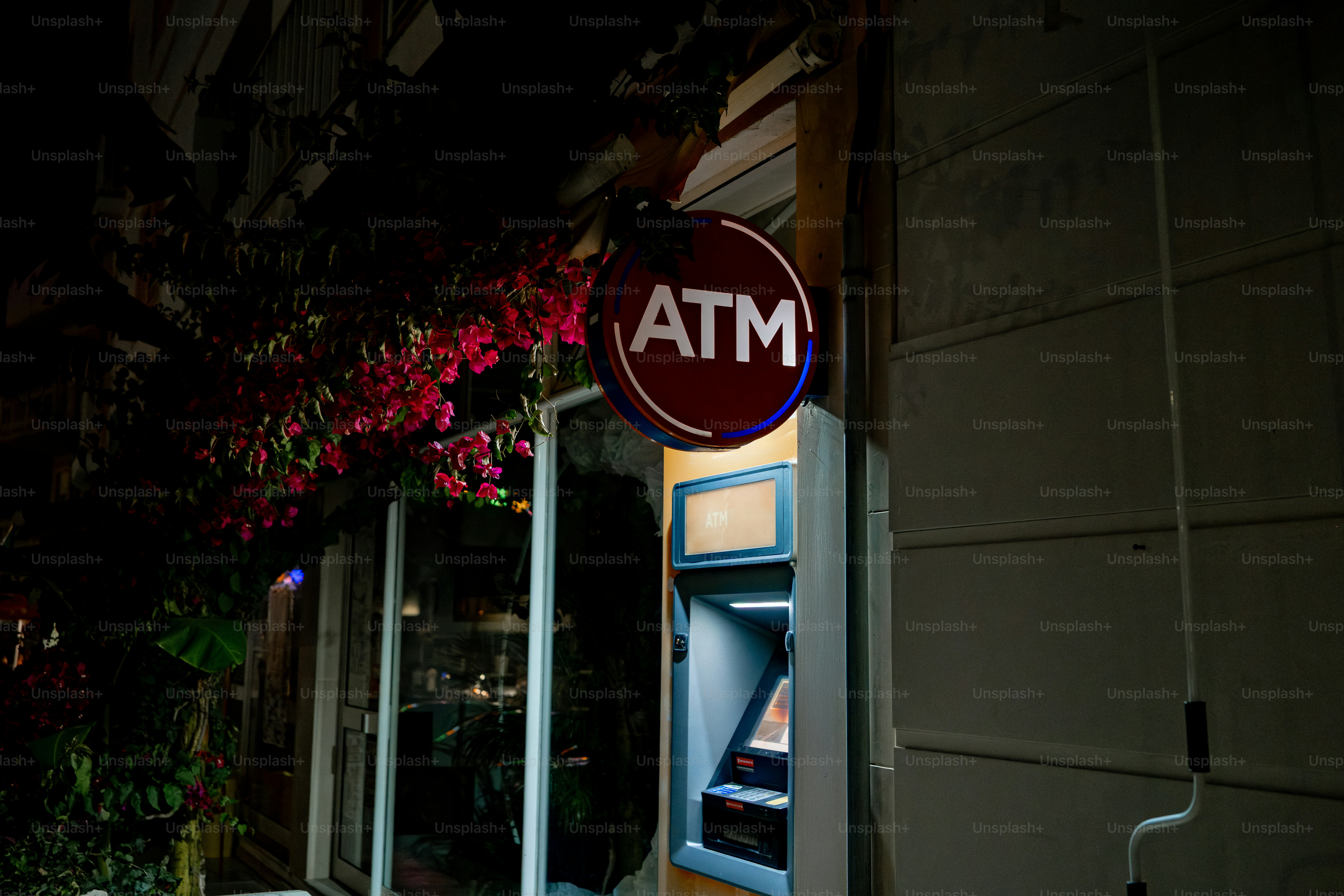 Atm machine glowing at night with red flowers photo – Money Image on ...