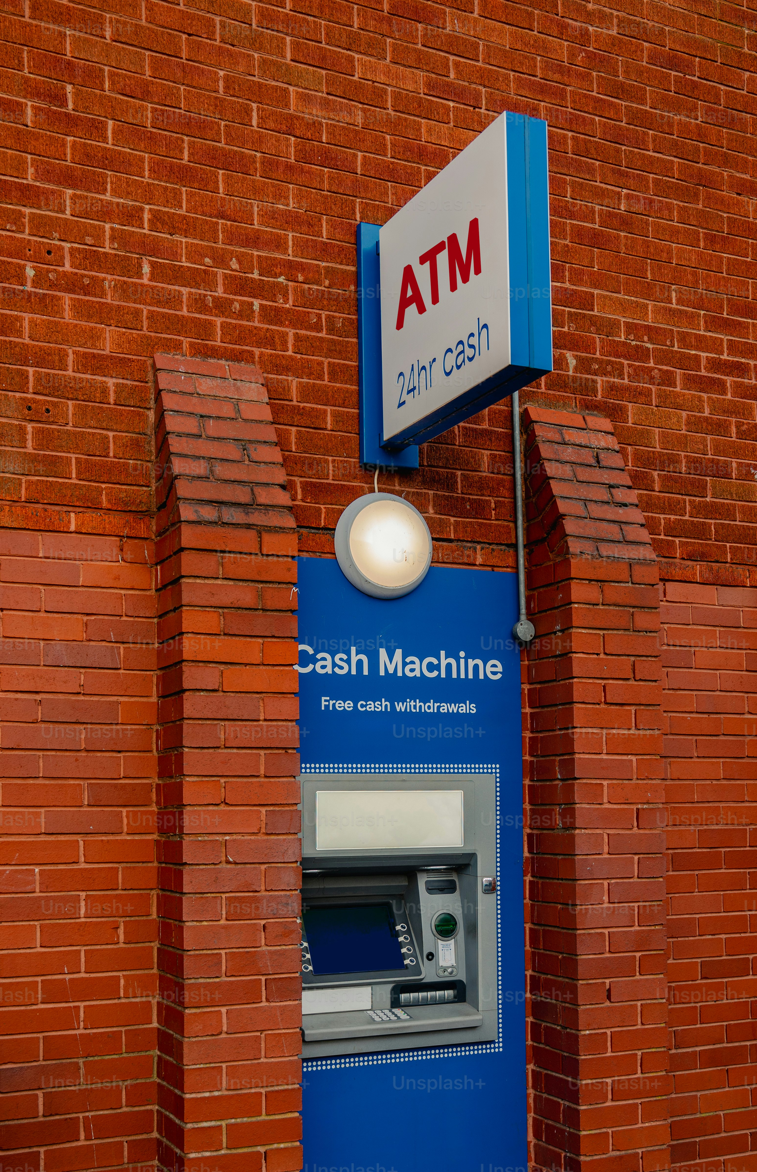 An atm cash machine on a brick wall. photo – Money Image on Unsplash