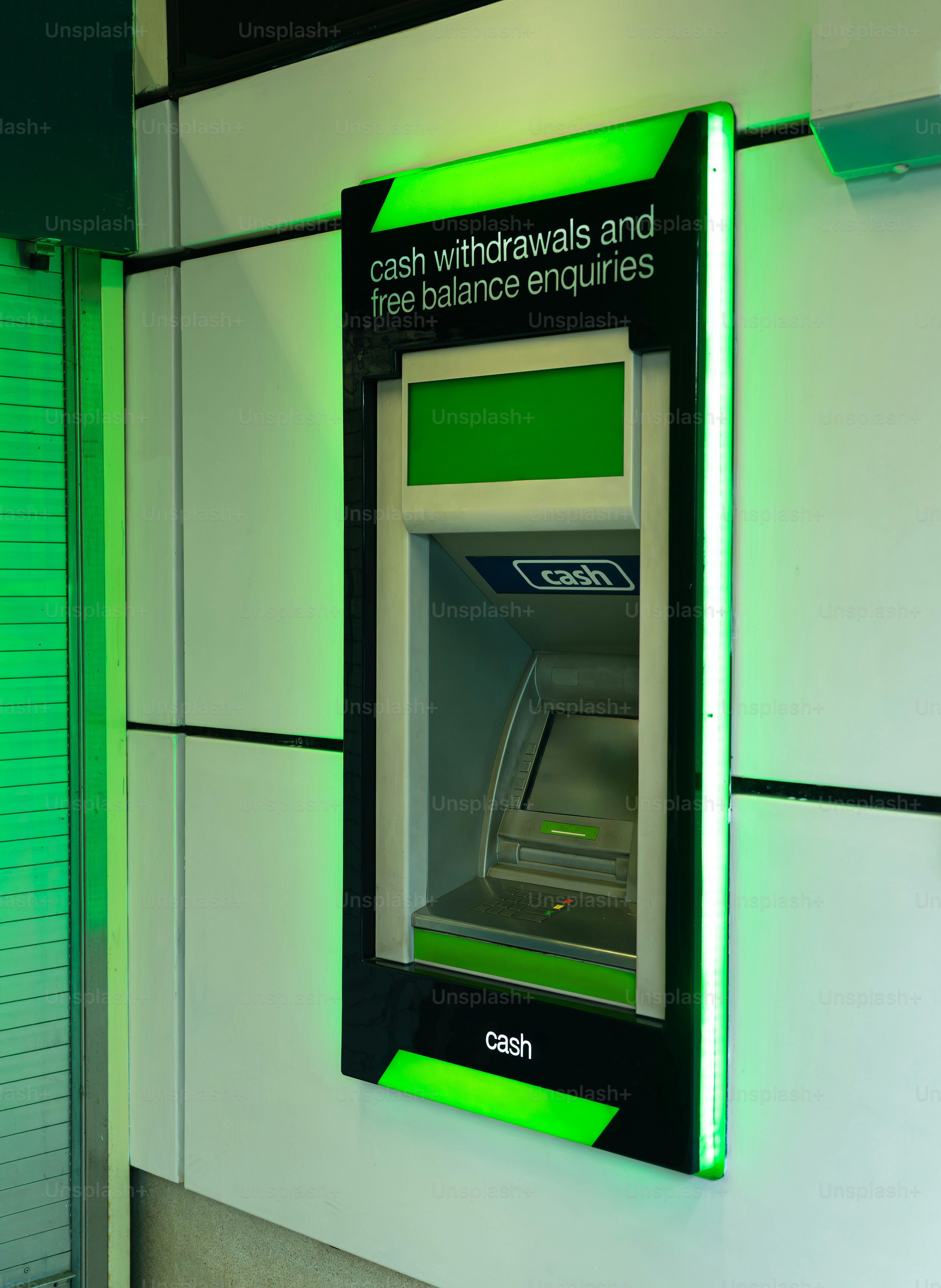 Un distributeur automatique de billets avec éclairage vert et texte ...