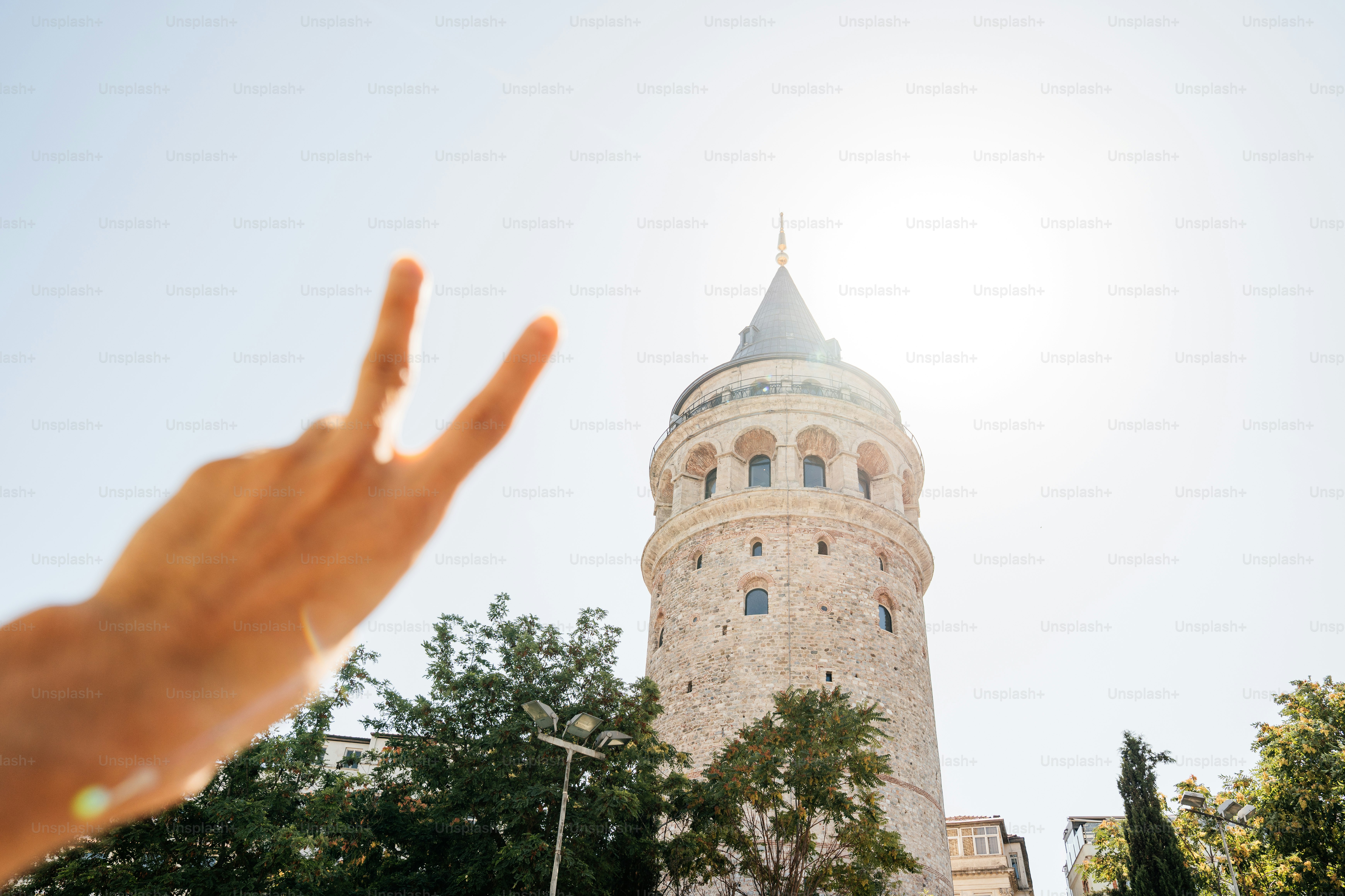 Person making peace sign with galata tower behind photo – Travel Image ...