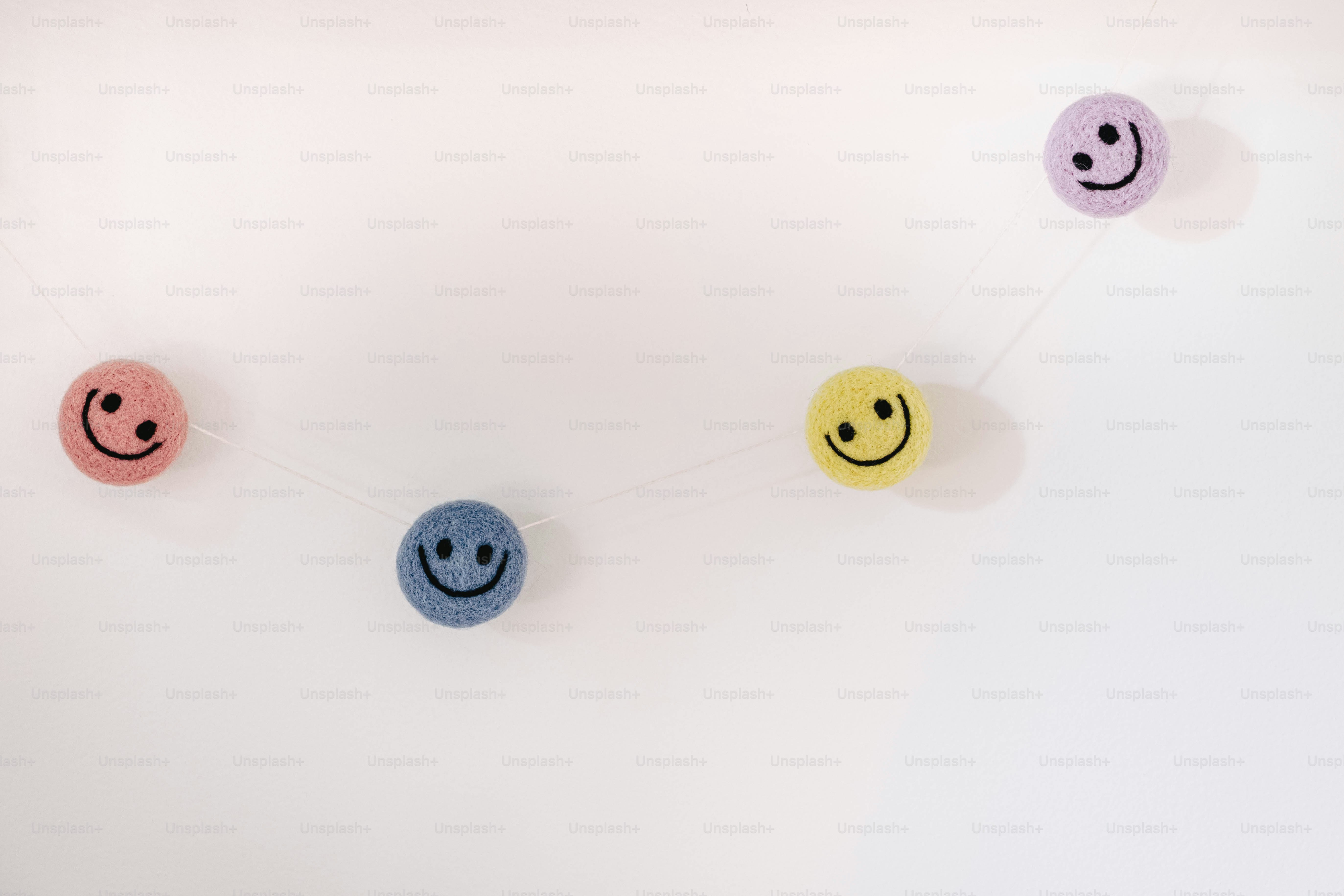 Four colorful smiley face ornaments on a string. photo – Blue Image on ...