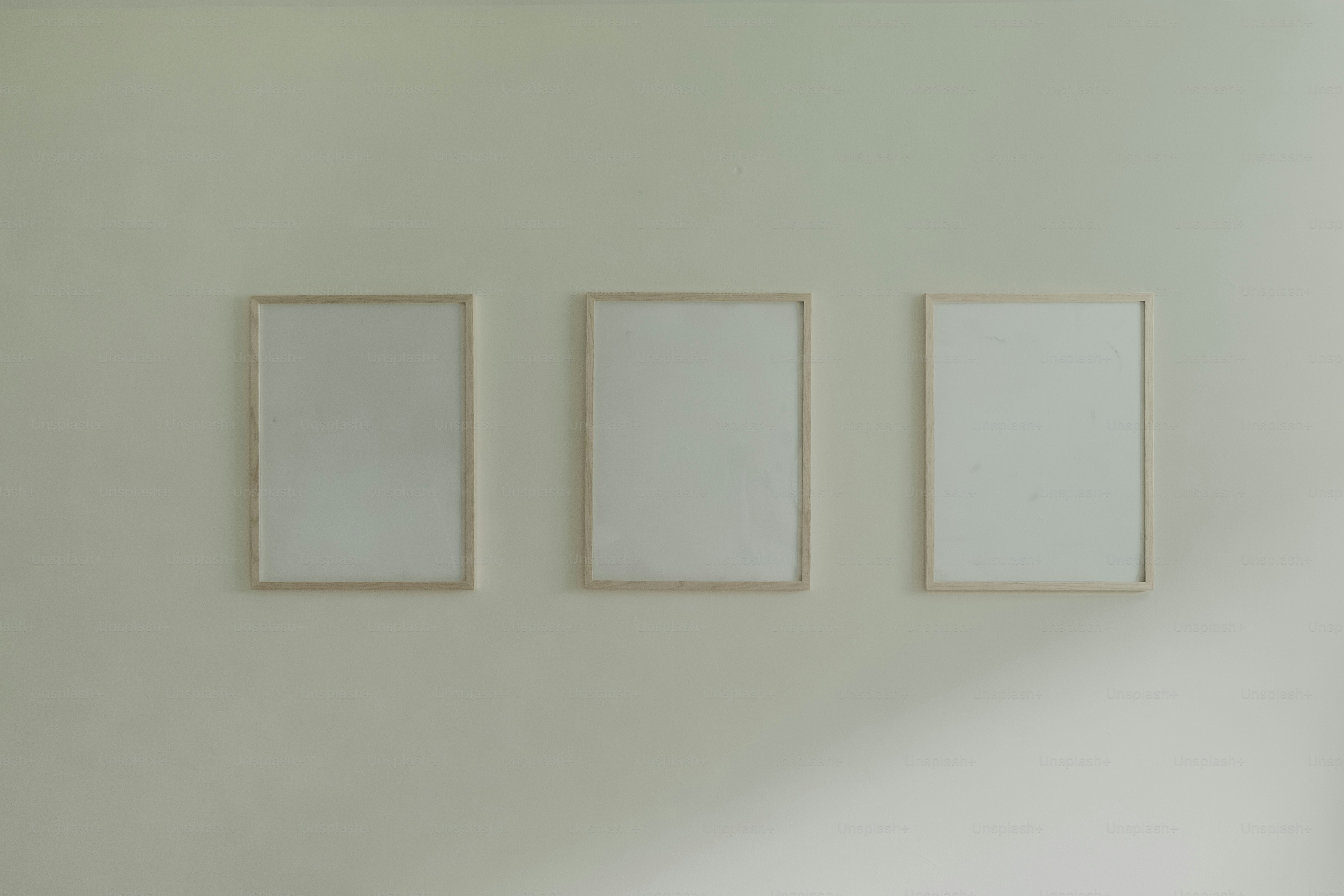 Three empty frames on a light wall. photo – Toddler Image on Unsplash