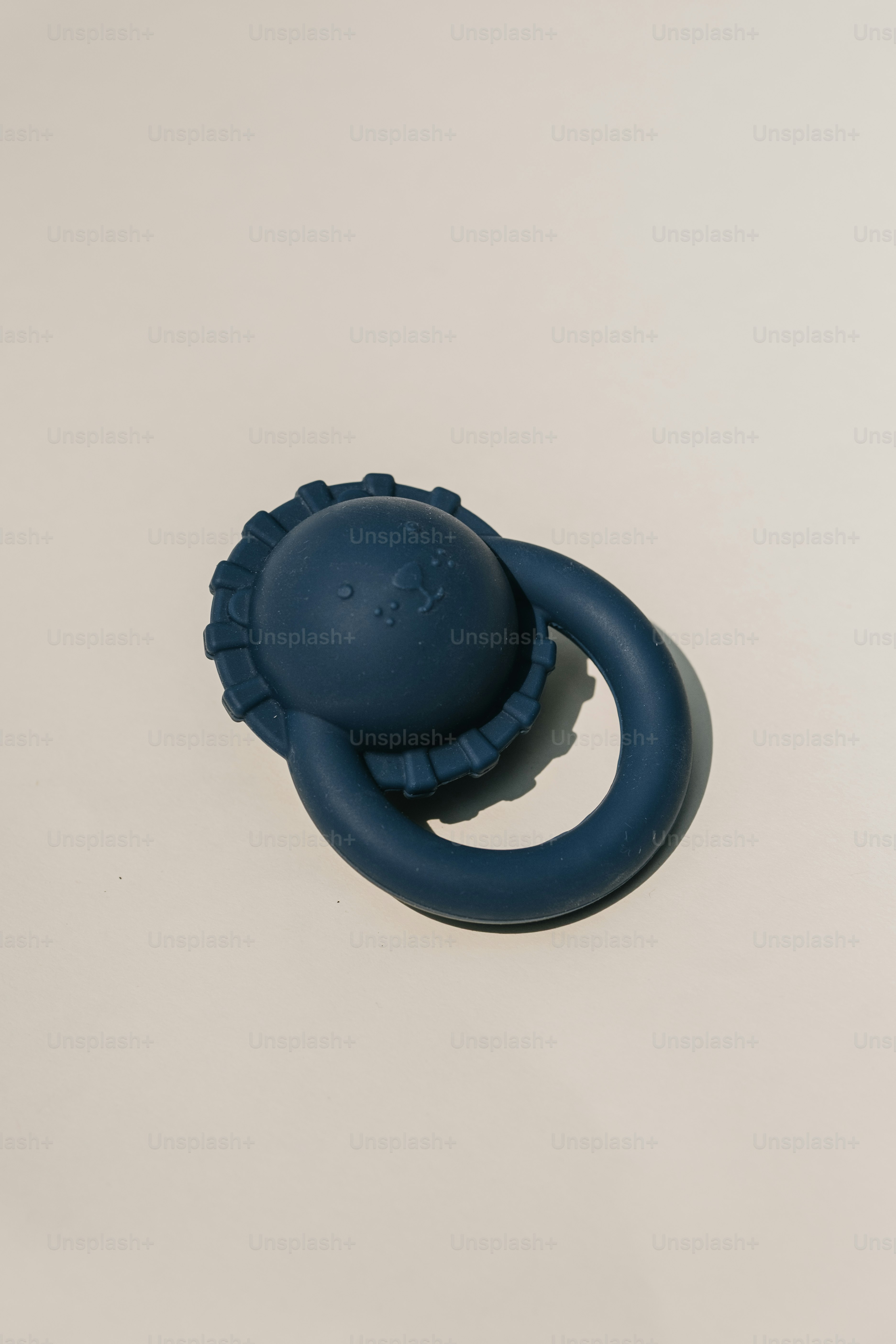 A dark blue baby rattle on a light background photo – Toddler Image on ...
