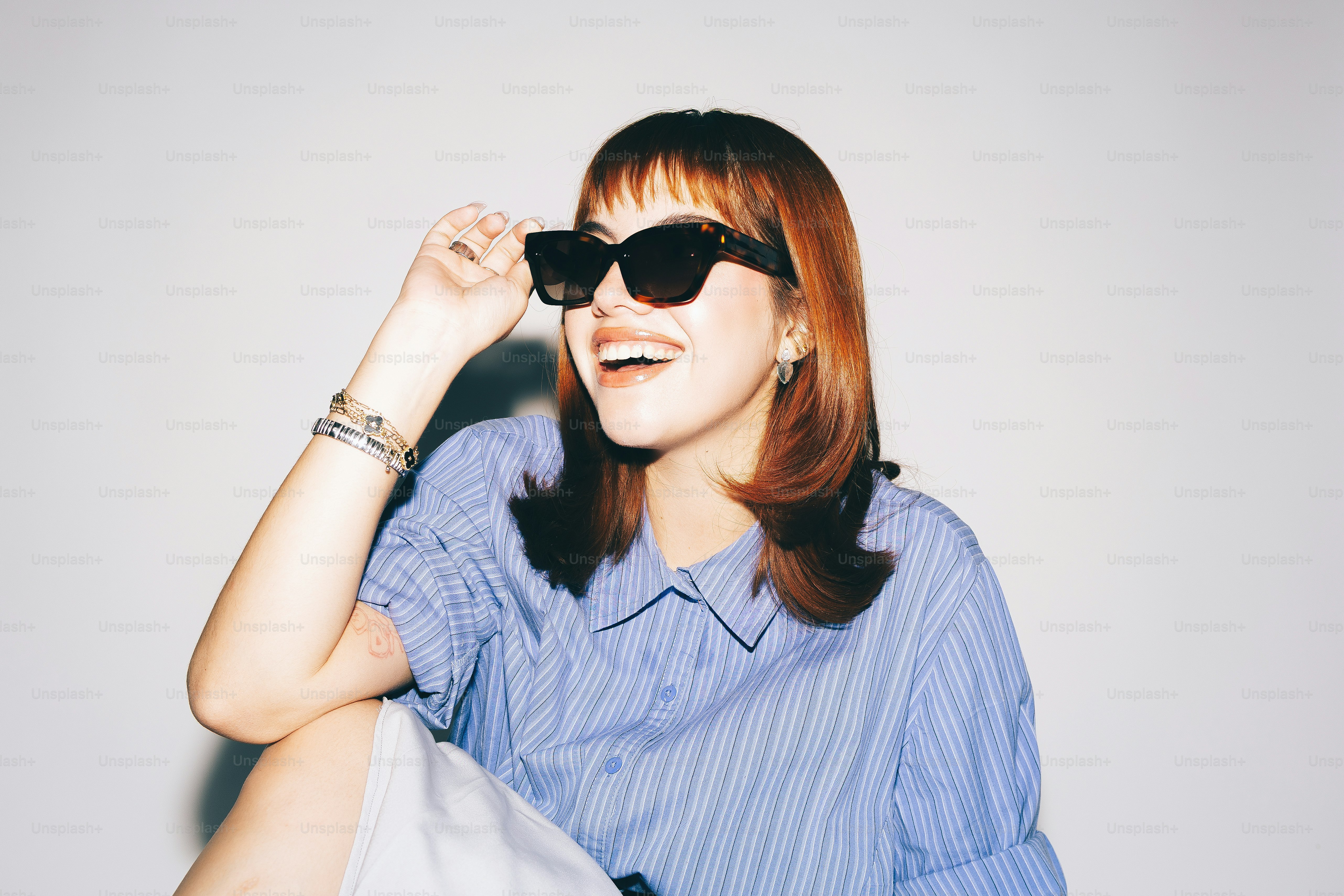 Mujer con gafas de sol se las ajusta con una sonrisa. foto – Imagen de ...