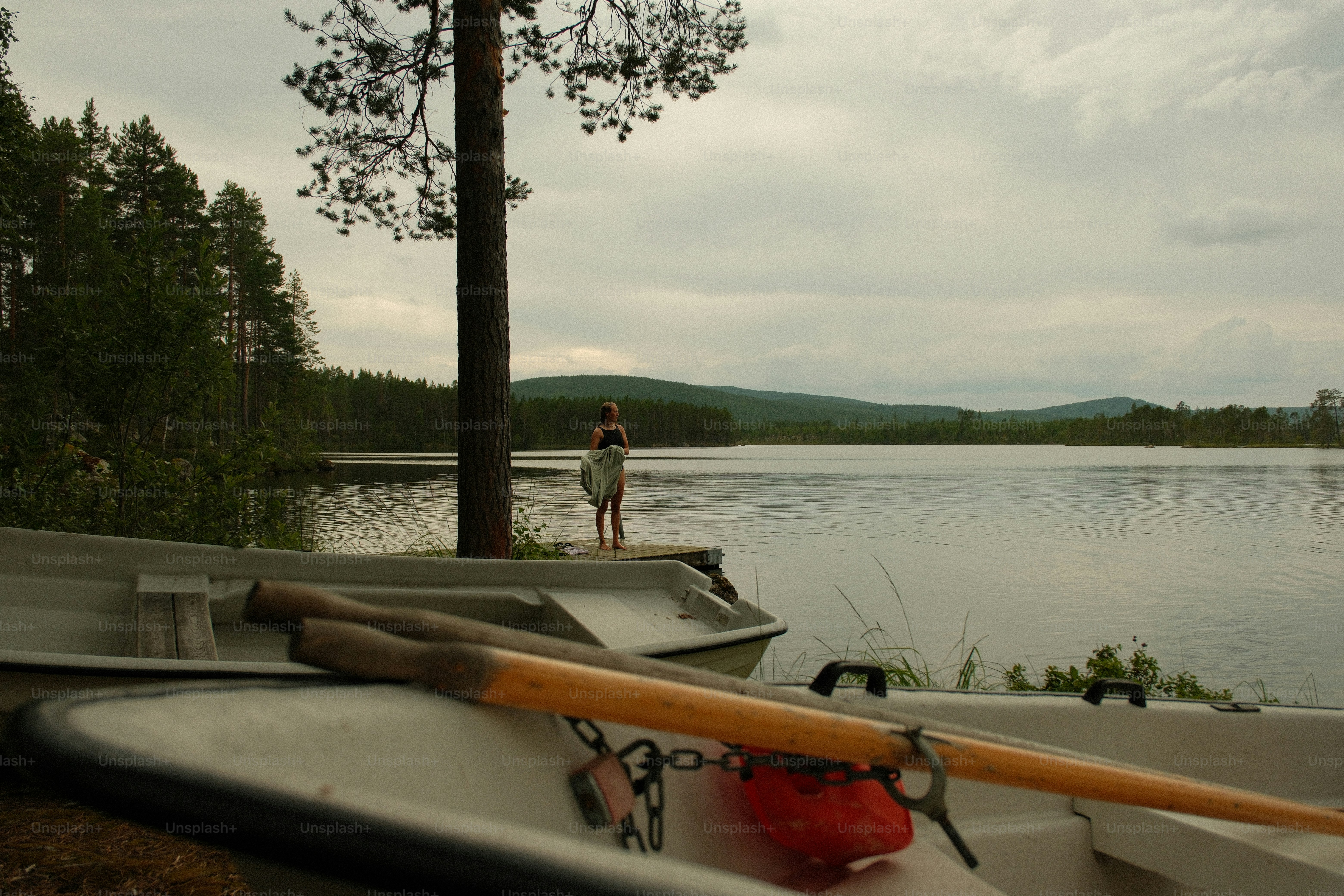 Two boats with oars rest by a serene lake. photo – Travel Image on Unsplash