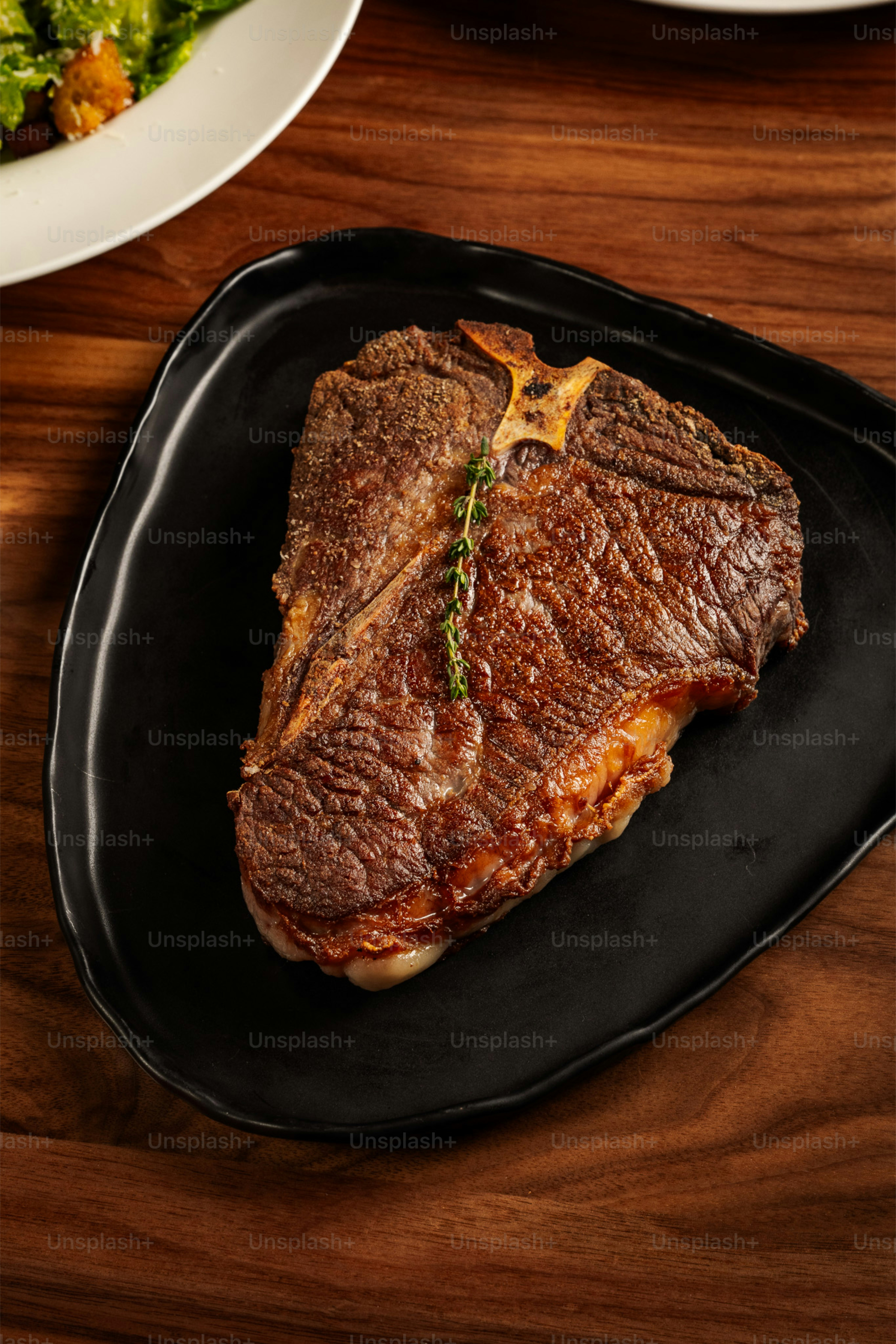 Un chuletón perfectamente cocido en un plato negro. foto – Imagen de ...