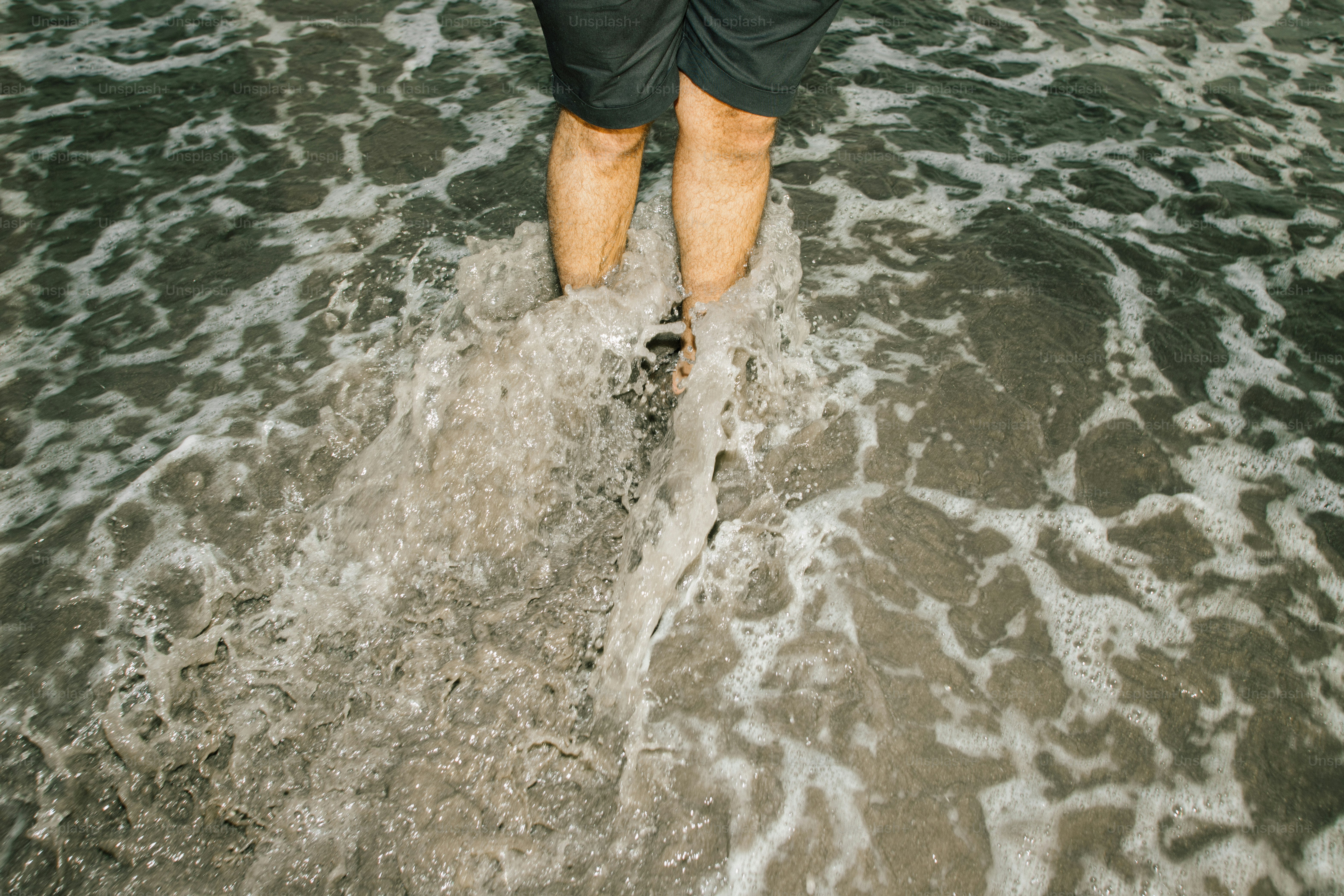 Person's legs standing in ocean waves photo – Beach Image on Unsplash