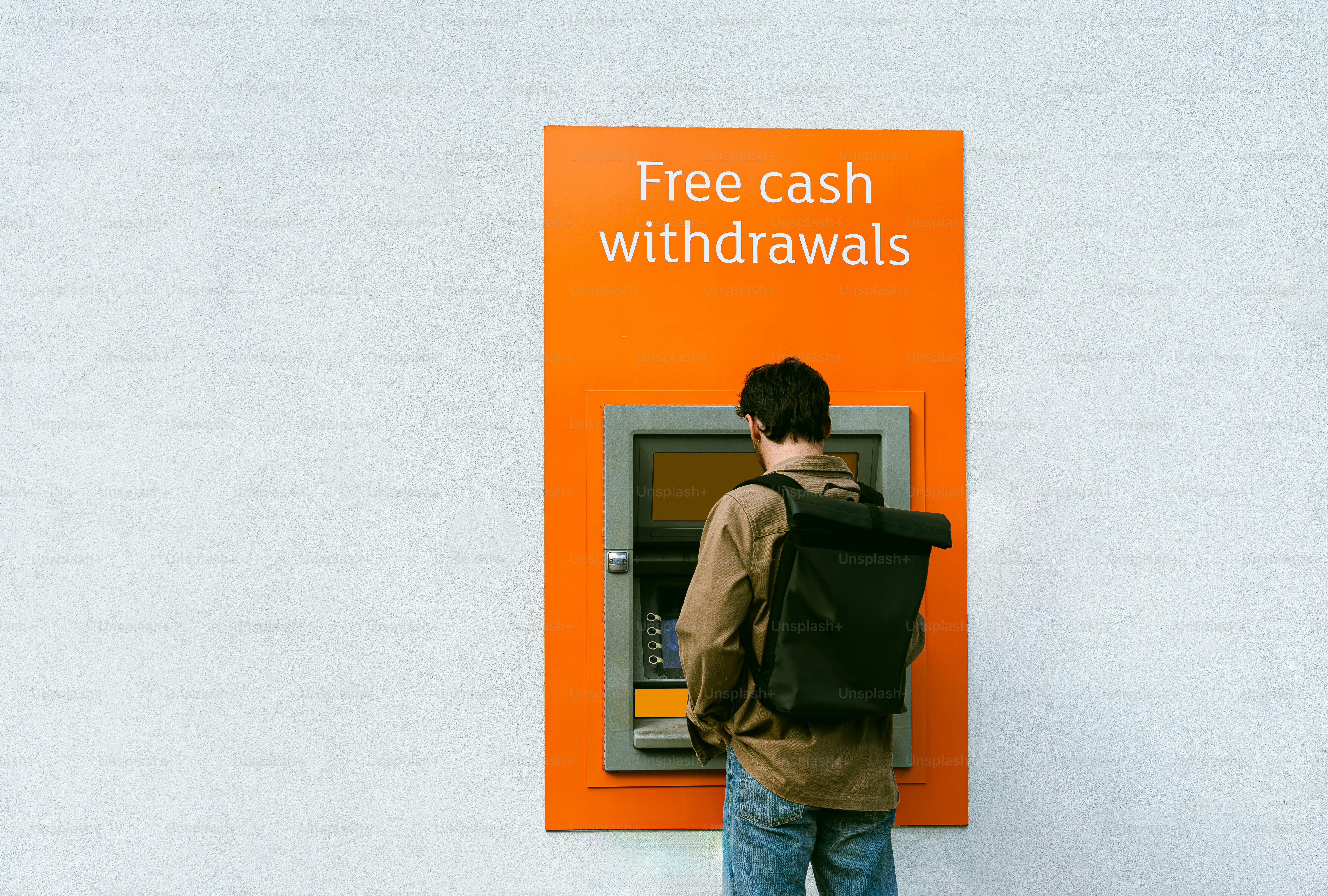 Hand holding orange card near atm with free withdrawals. photo – Money ...