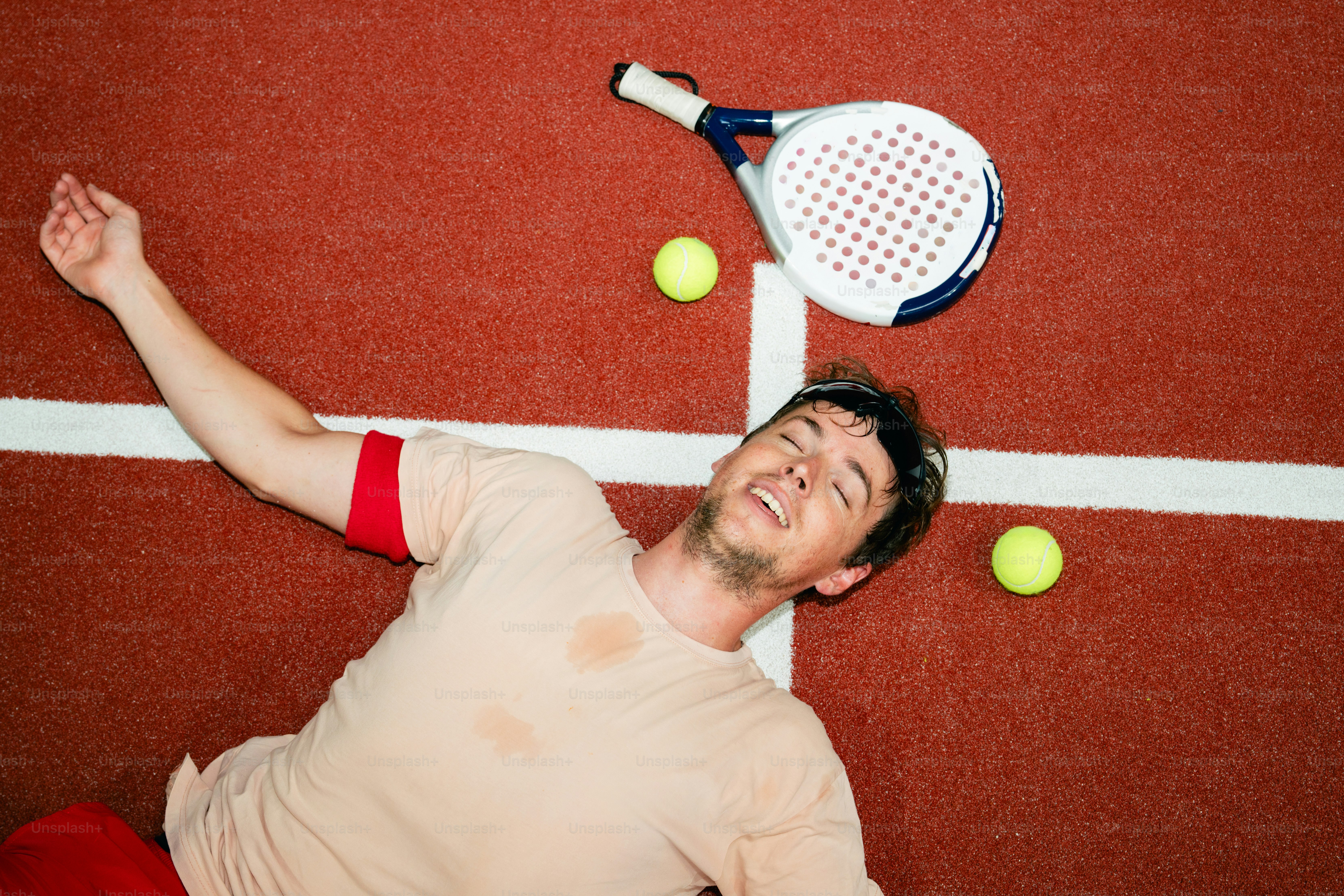 Exhausted man lying on tennis court with racket and balls photo ...