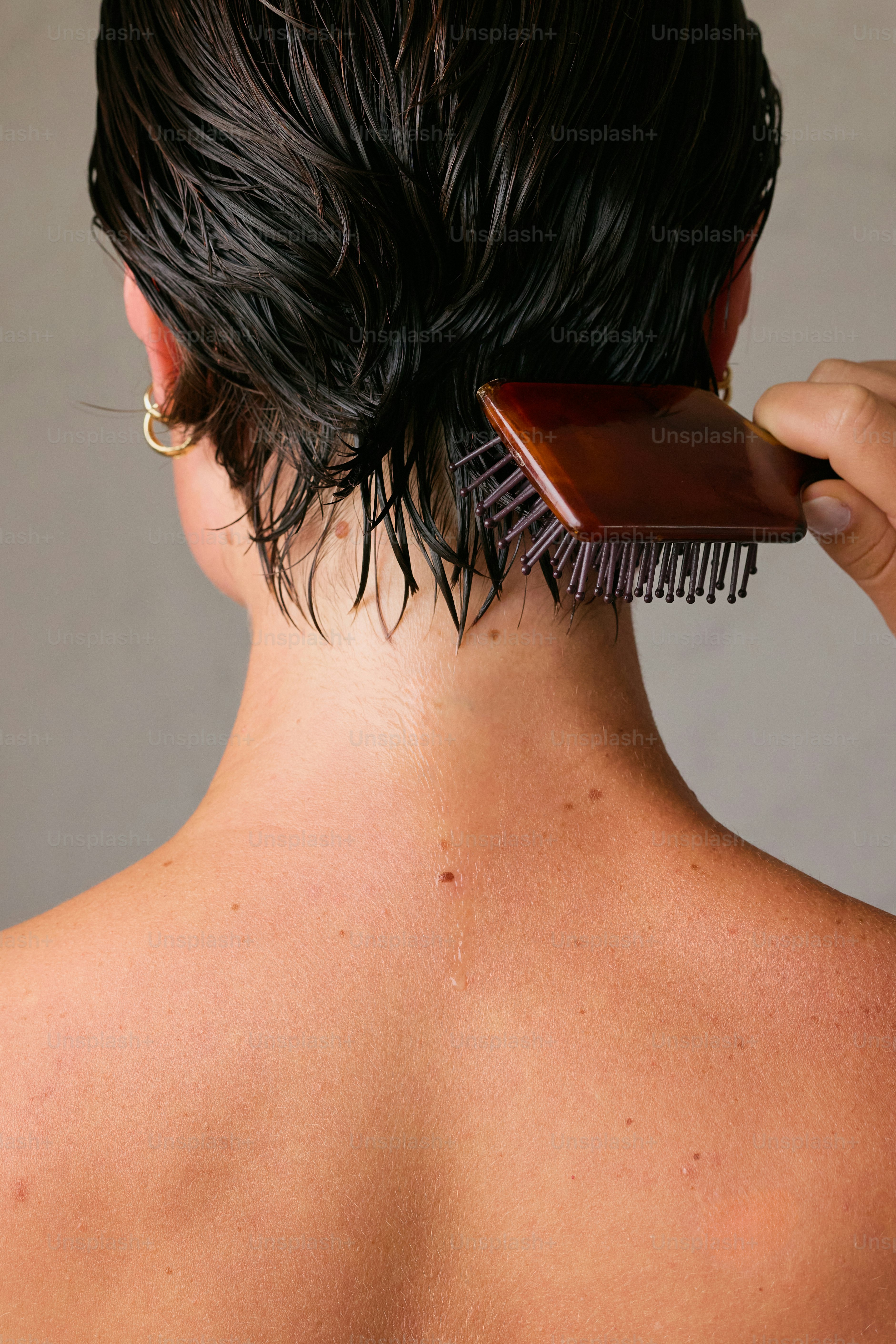 Woman brushing wet short hair with a brown brush. photo – Beauty Image ...