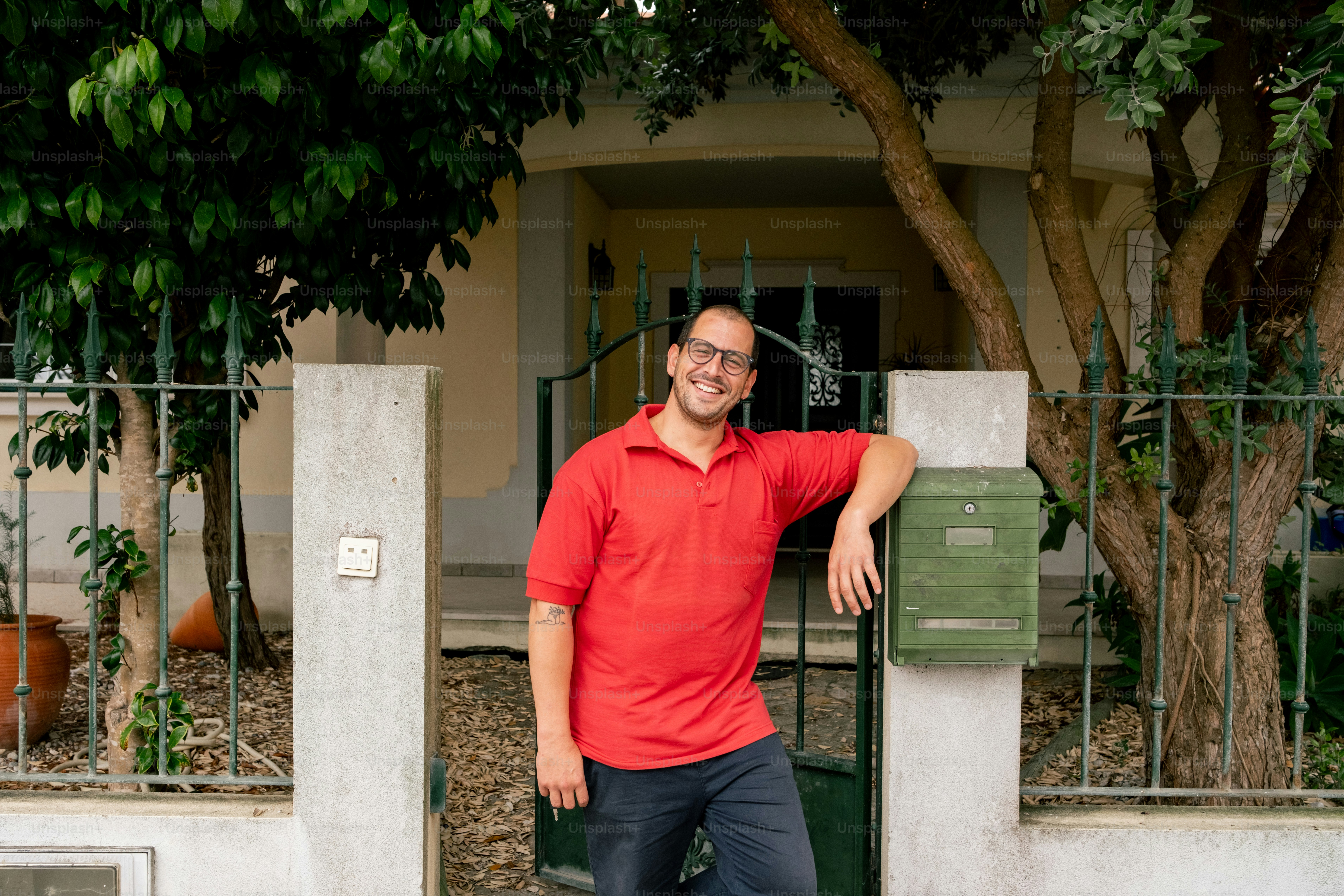 Man in red shirt standing outside a house. photo – Portrait Image on ...