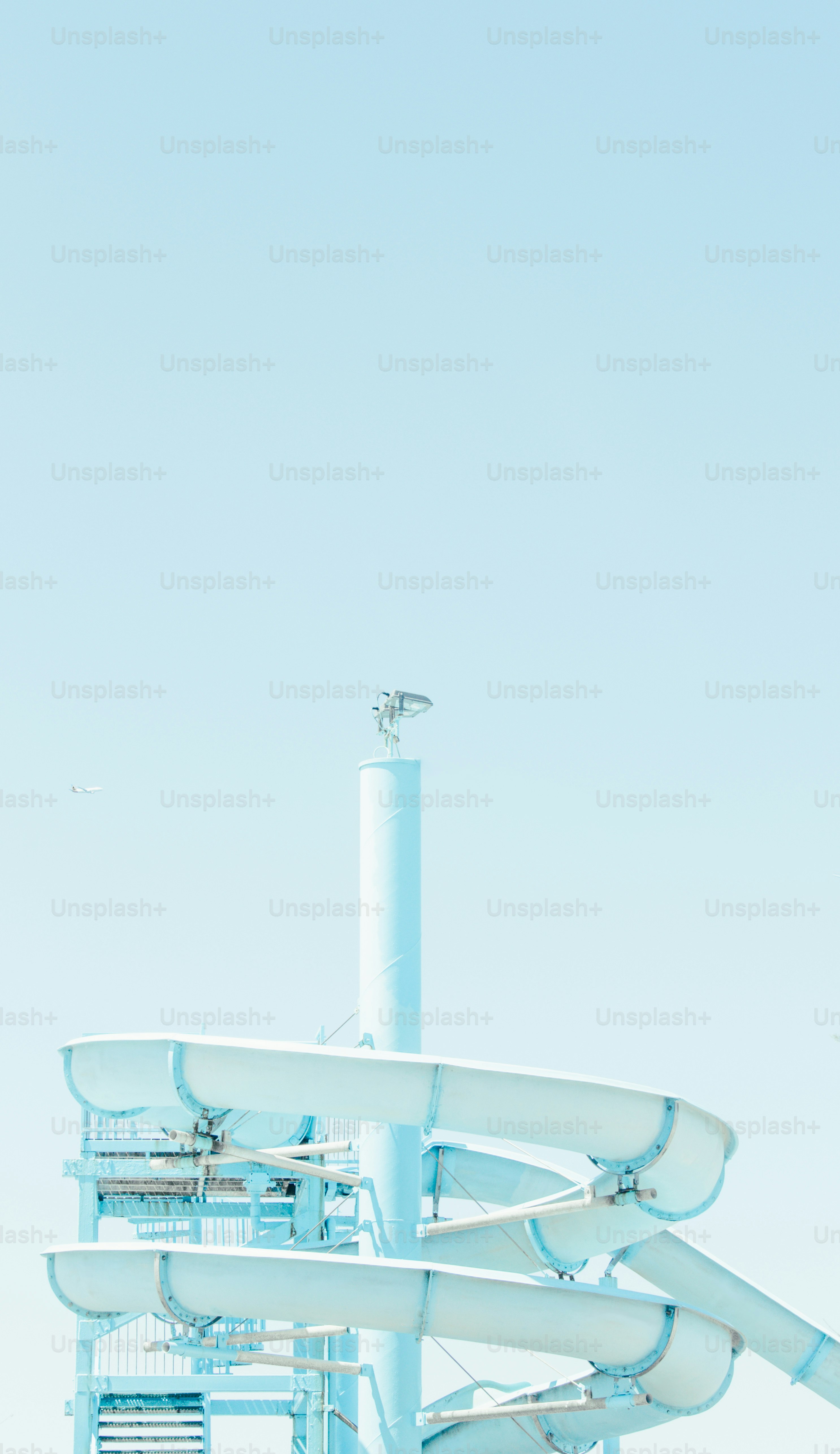 A light blue water slide against a clear sky photo – Architecture Image ...
