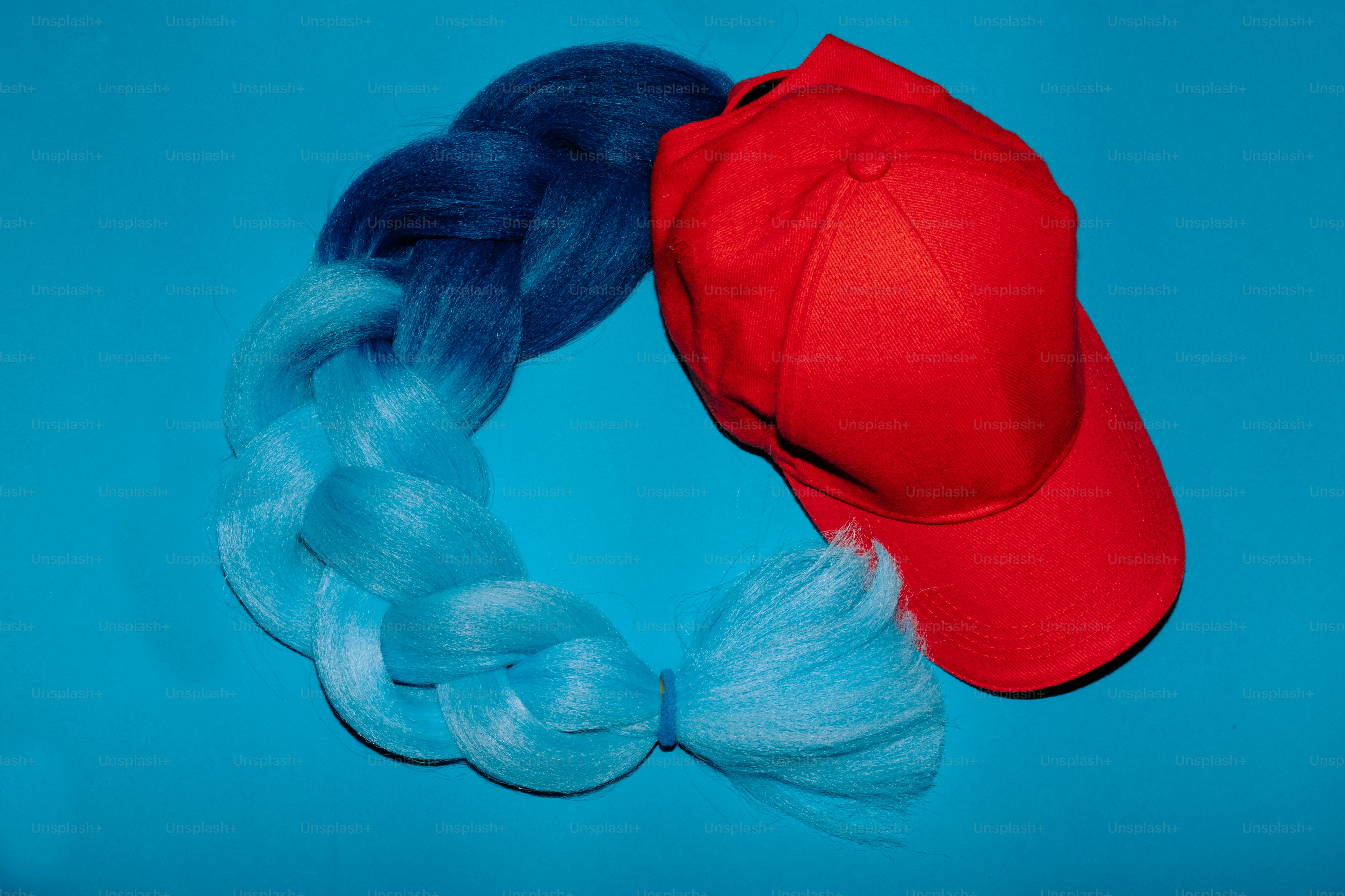 Hand holding a red baseball cap against blue sky. photo – Color Image ...