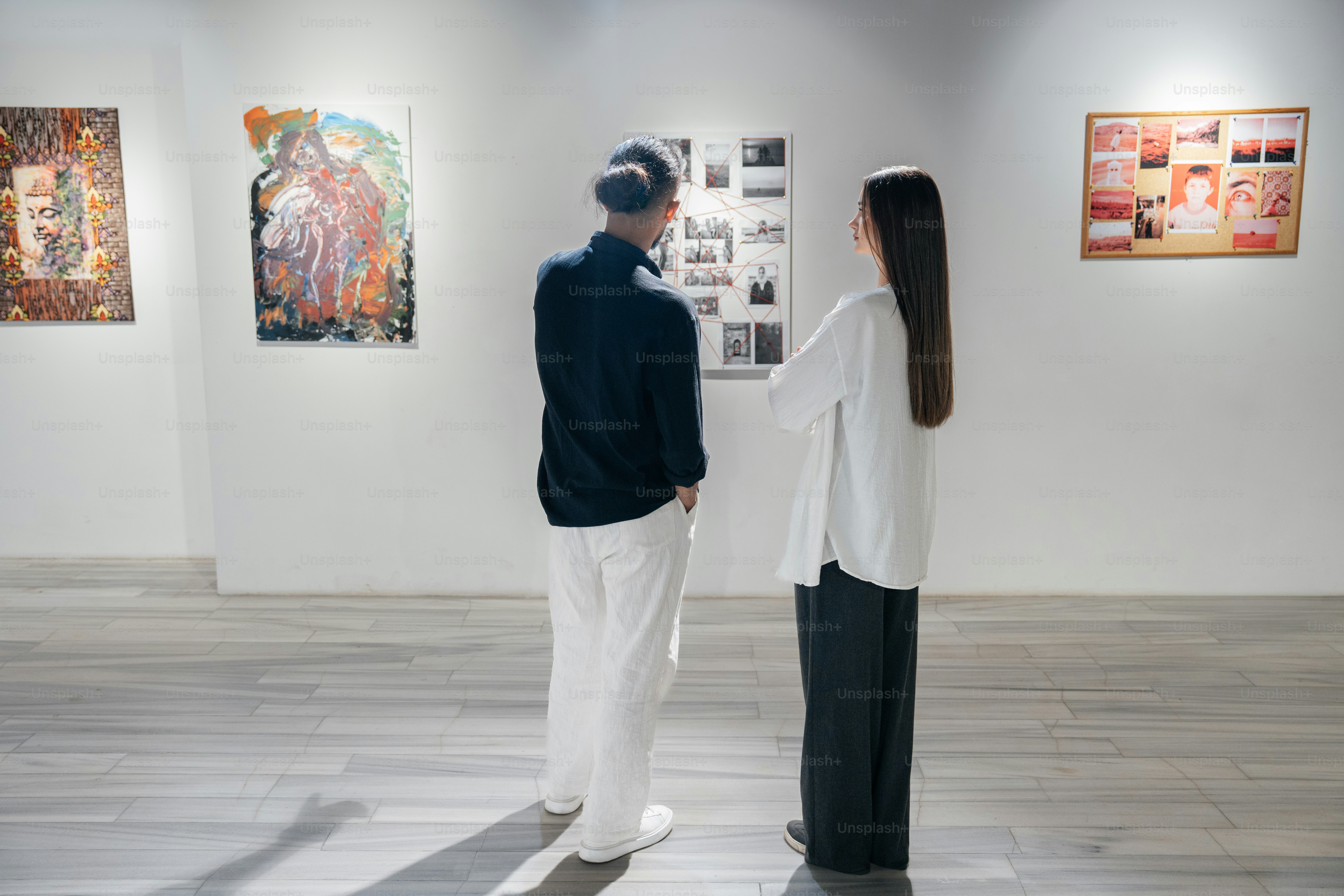 Two people observing artwork in a modern gallery. photo – Art Image on ...