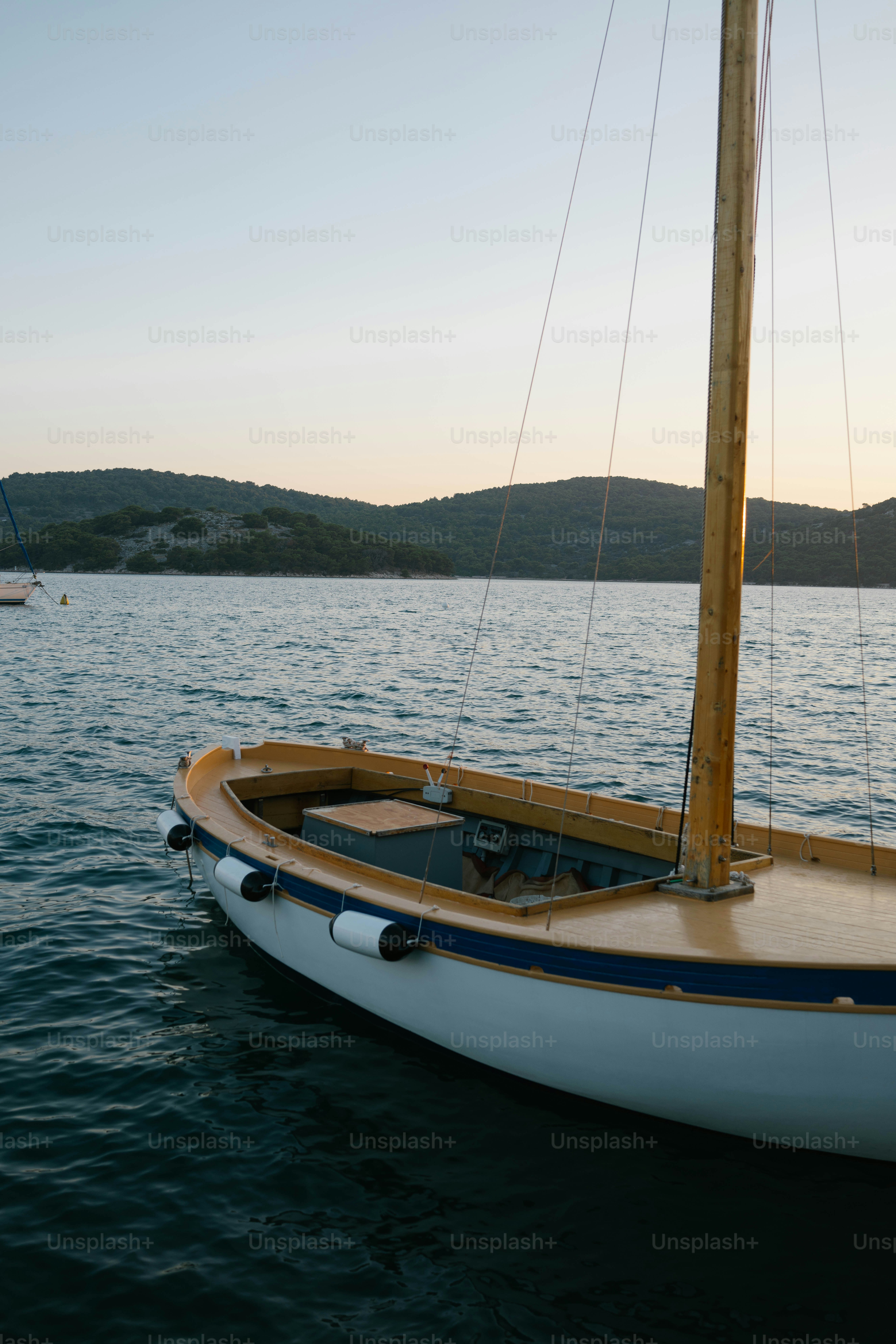 A small sailboat floats on calm water near shore. photo – Travel Image ...
