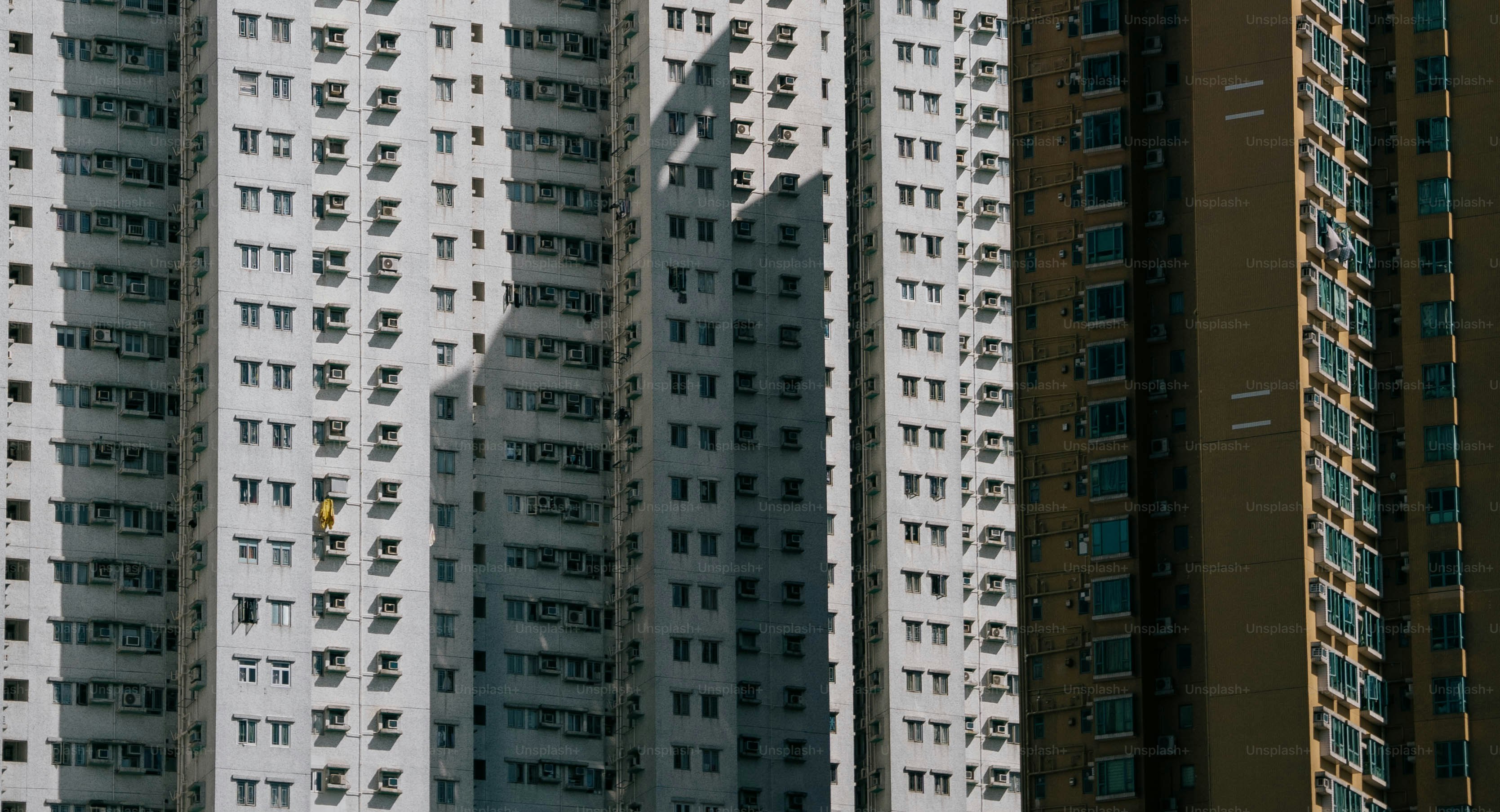 Tall apartment buildings with many windows casting shadows photo ...