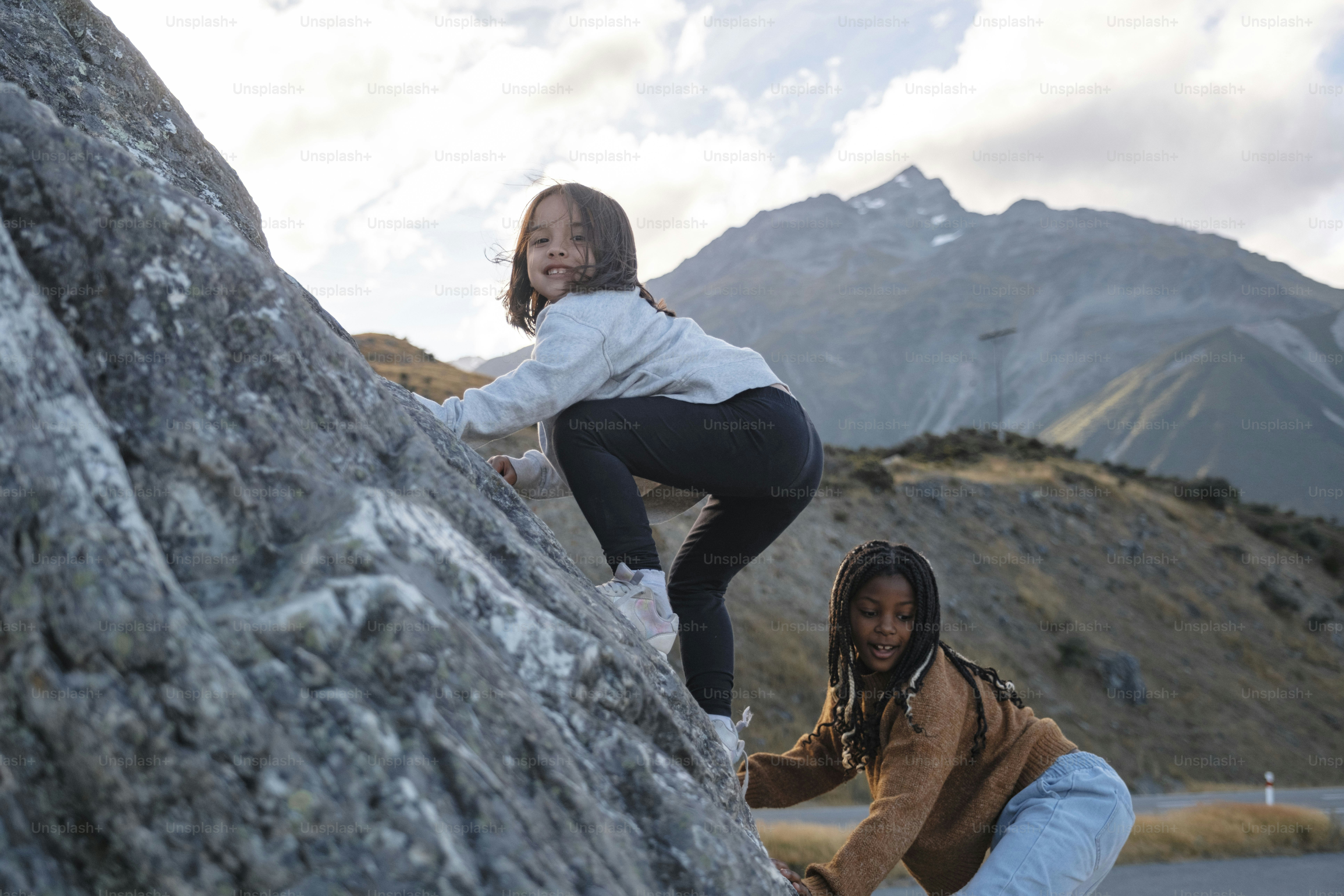 Two girls climbing a large rock outdoors photo – Travel Image on Unsplash