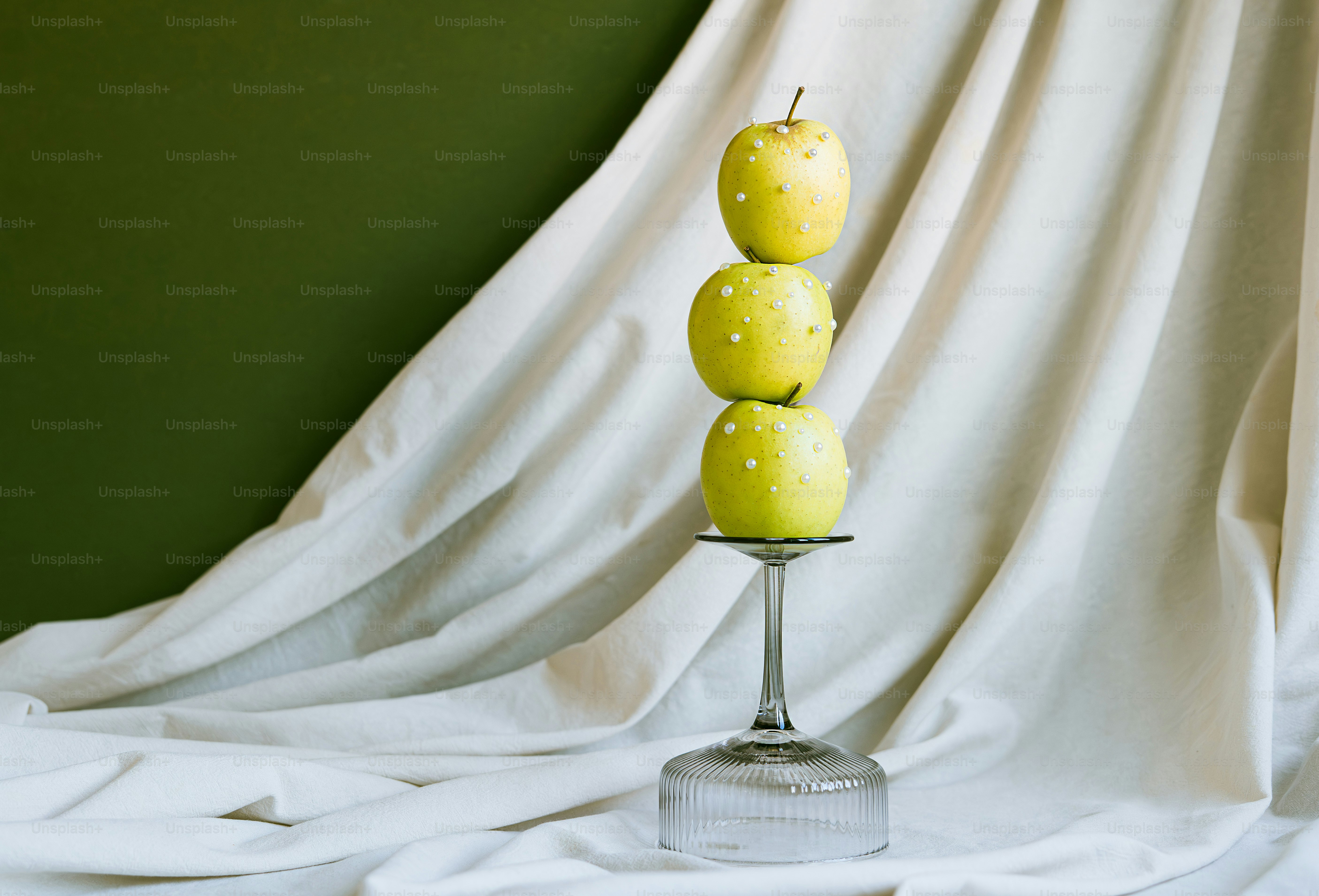 Three green apples stacked on a glass stand. photo – Fruit Image on ...