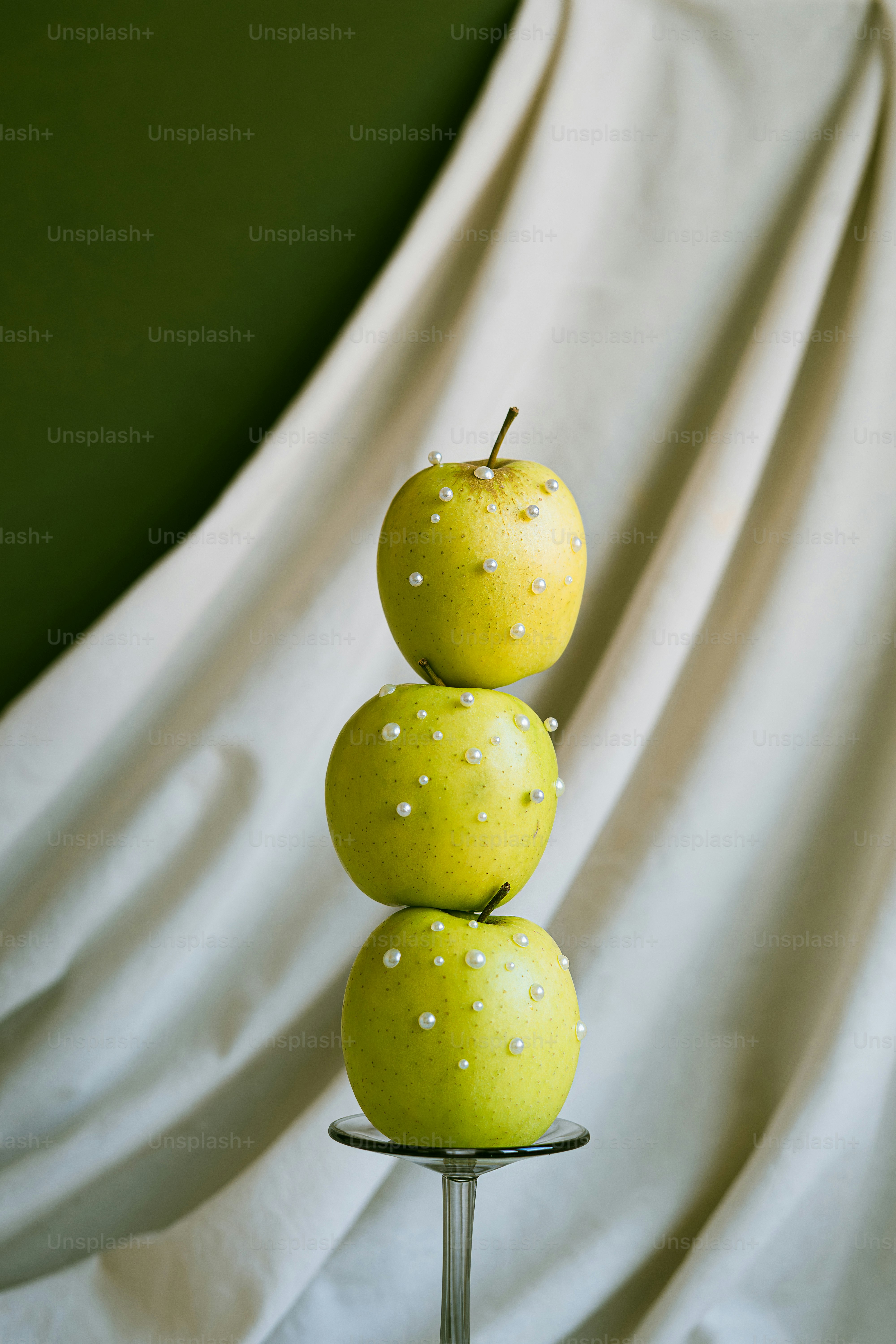 Three green apples decorated with pearls stacked vertically. photo ...