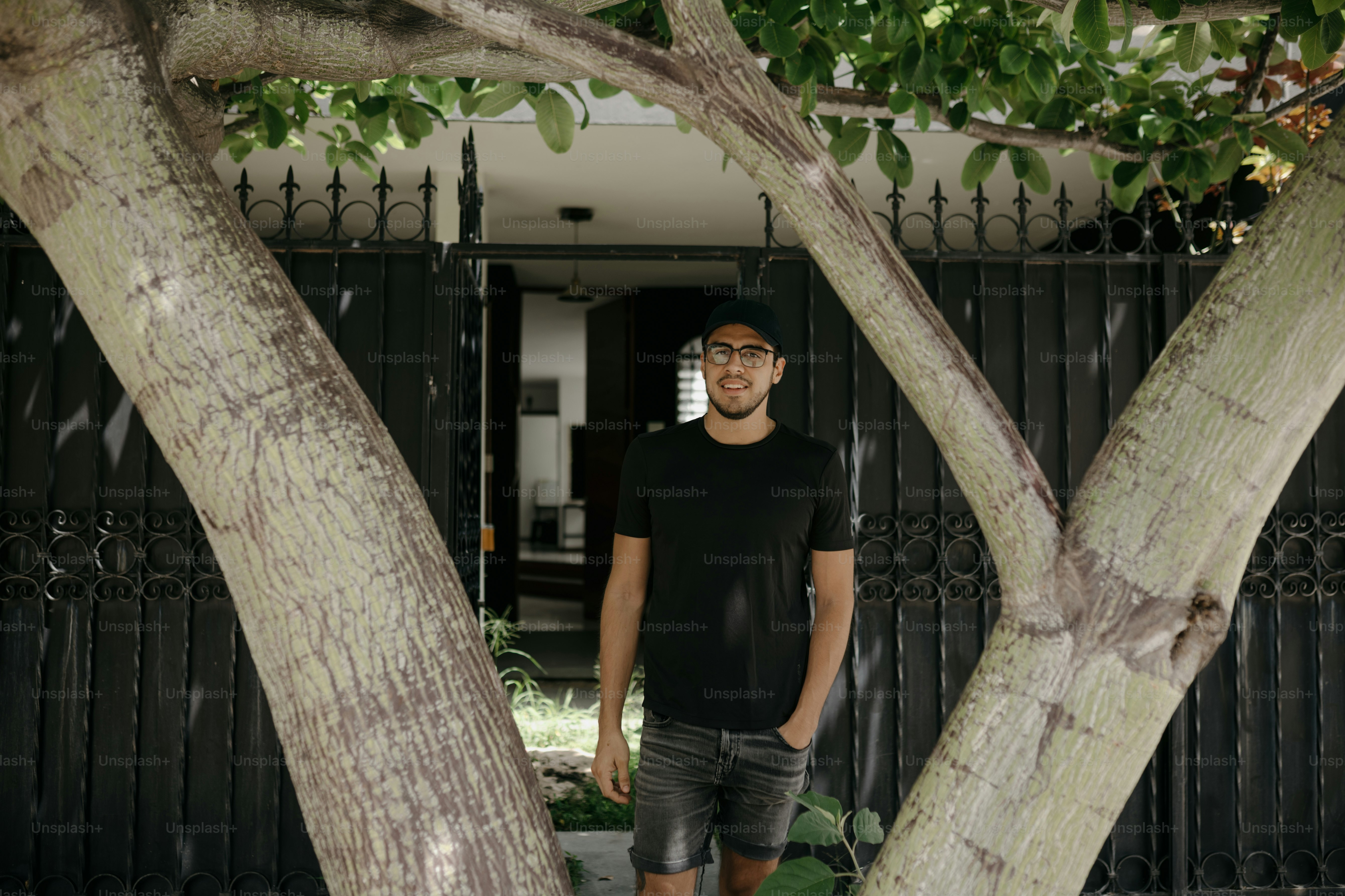 Man standing between two trees in front of a building photo – Portrait ...