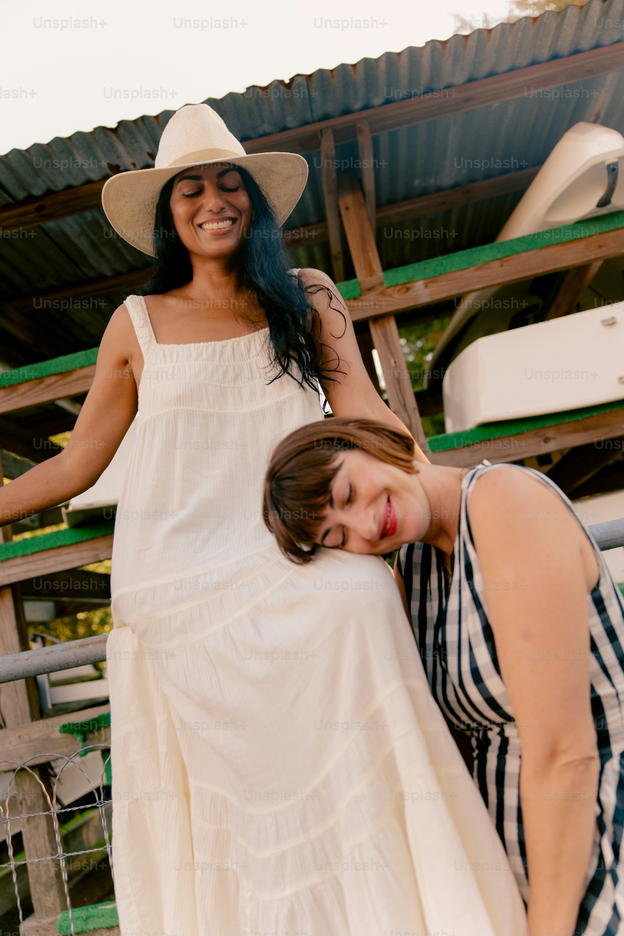 Two women stand in the rain looking up. photo – Women Image on Unsplash
