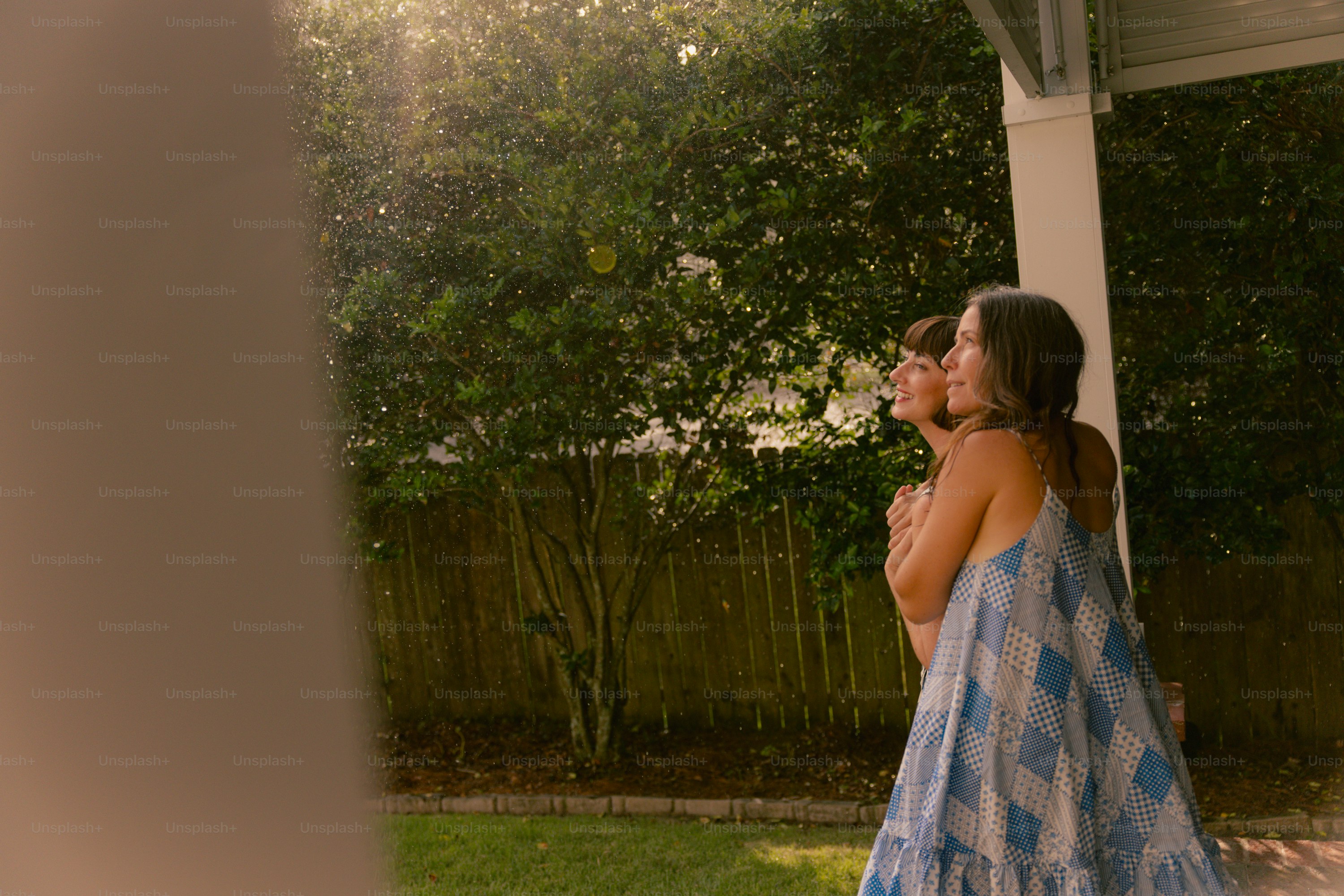 Two women stand in the rain looking up. photo – Women Image on Unsplash