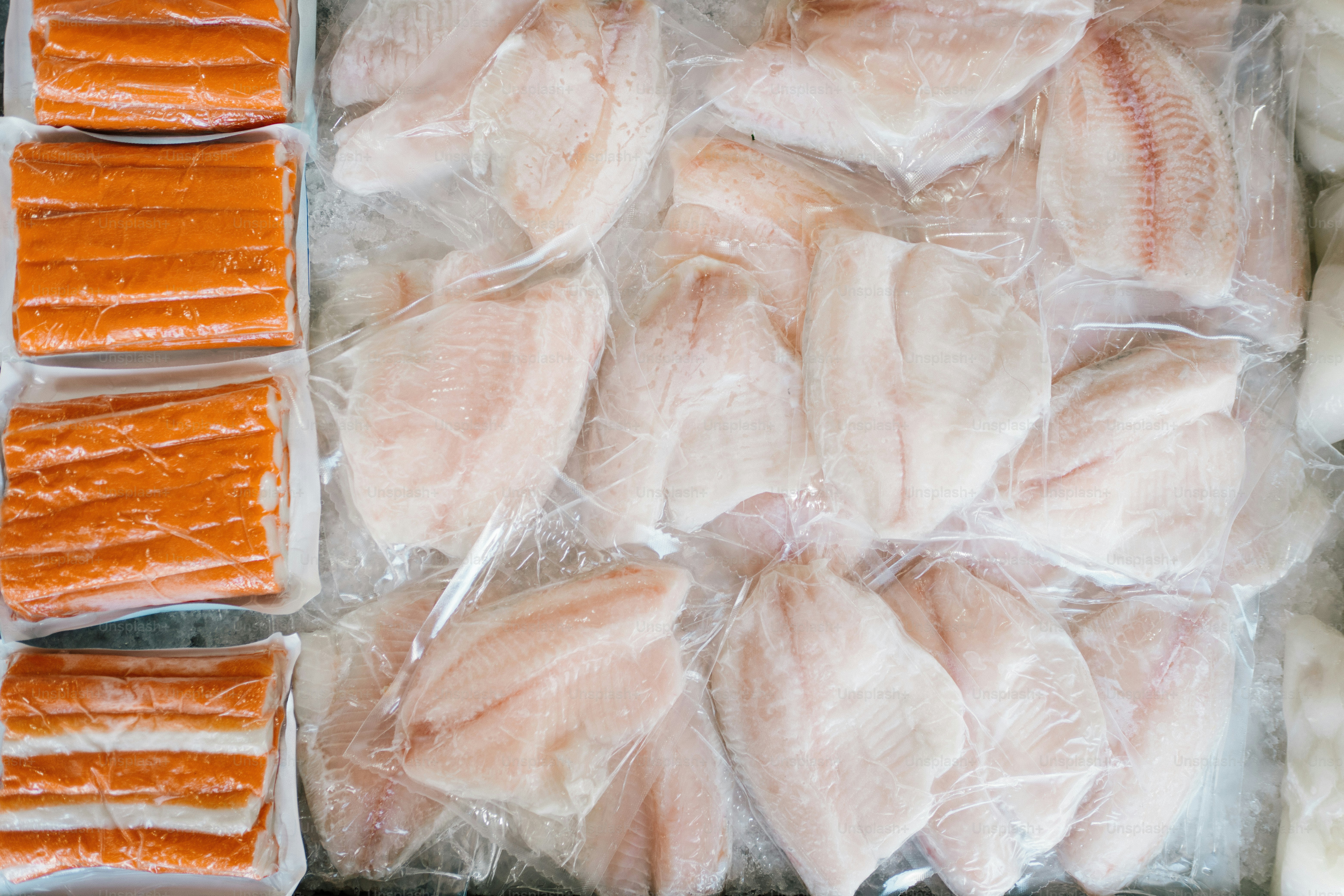 Packaged fish fillets and crab sticks in a display case. photo ...