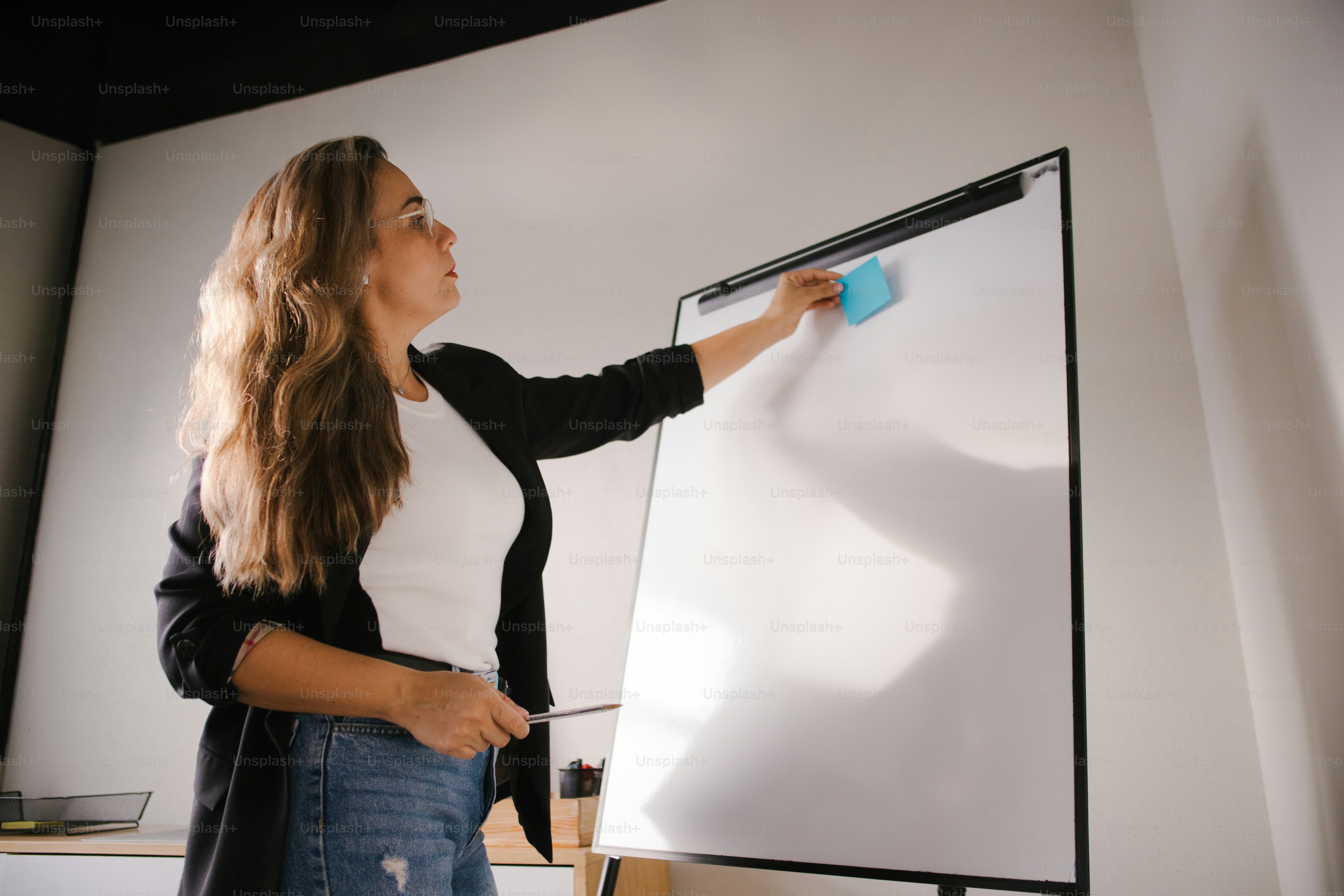 Woman placing sticky note on whiteboard photo – Female Image on Unsplash