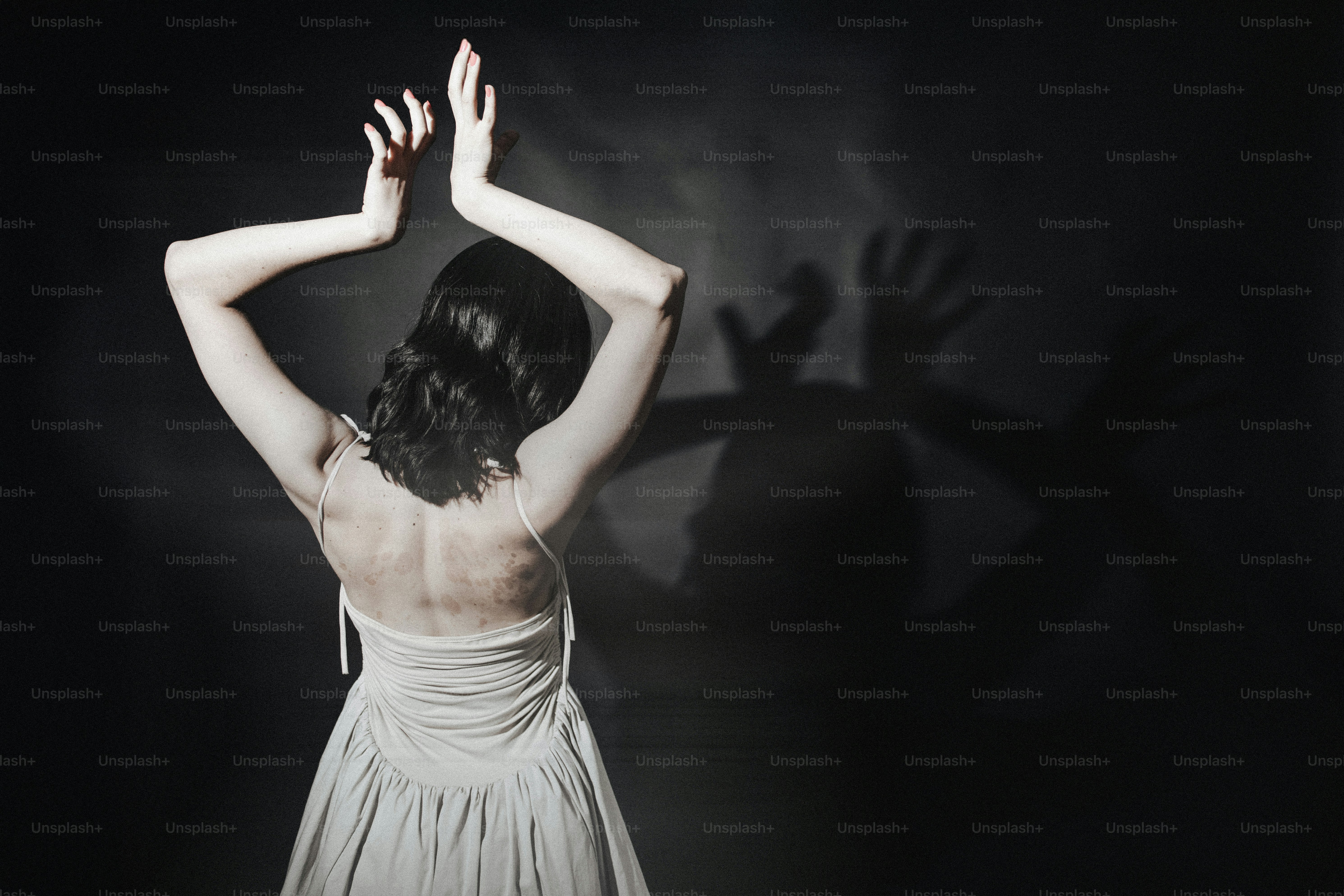 Woman in a light dress with arms raised, casting shadow. photo – Woman ...