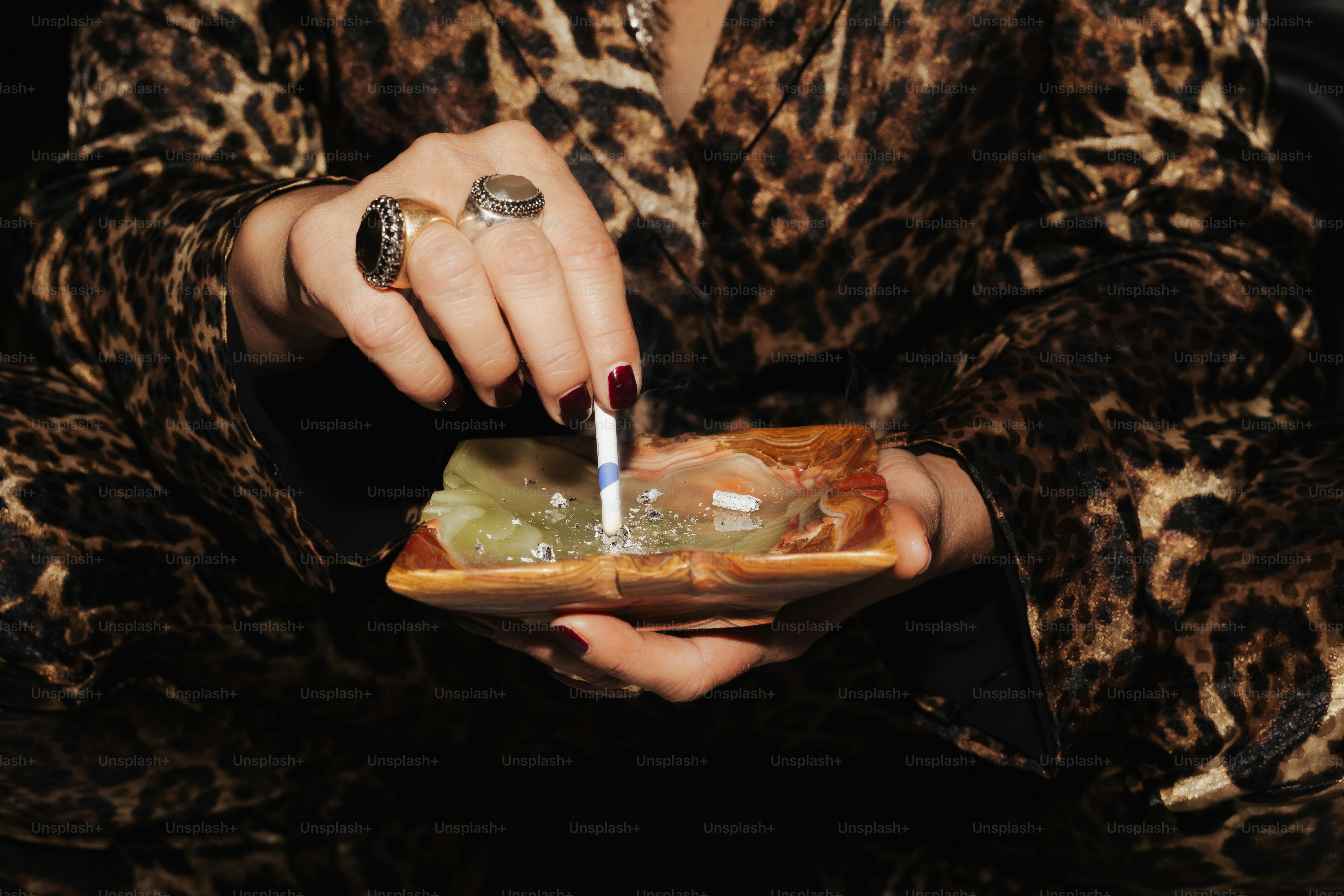 Woman in leopard print stirs drink with ice cubes. photo – Smoking ...
