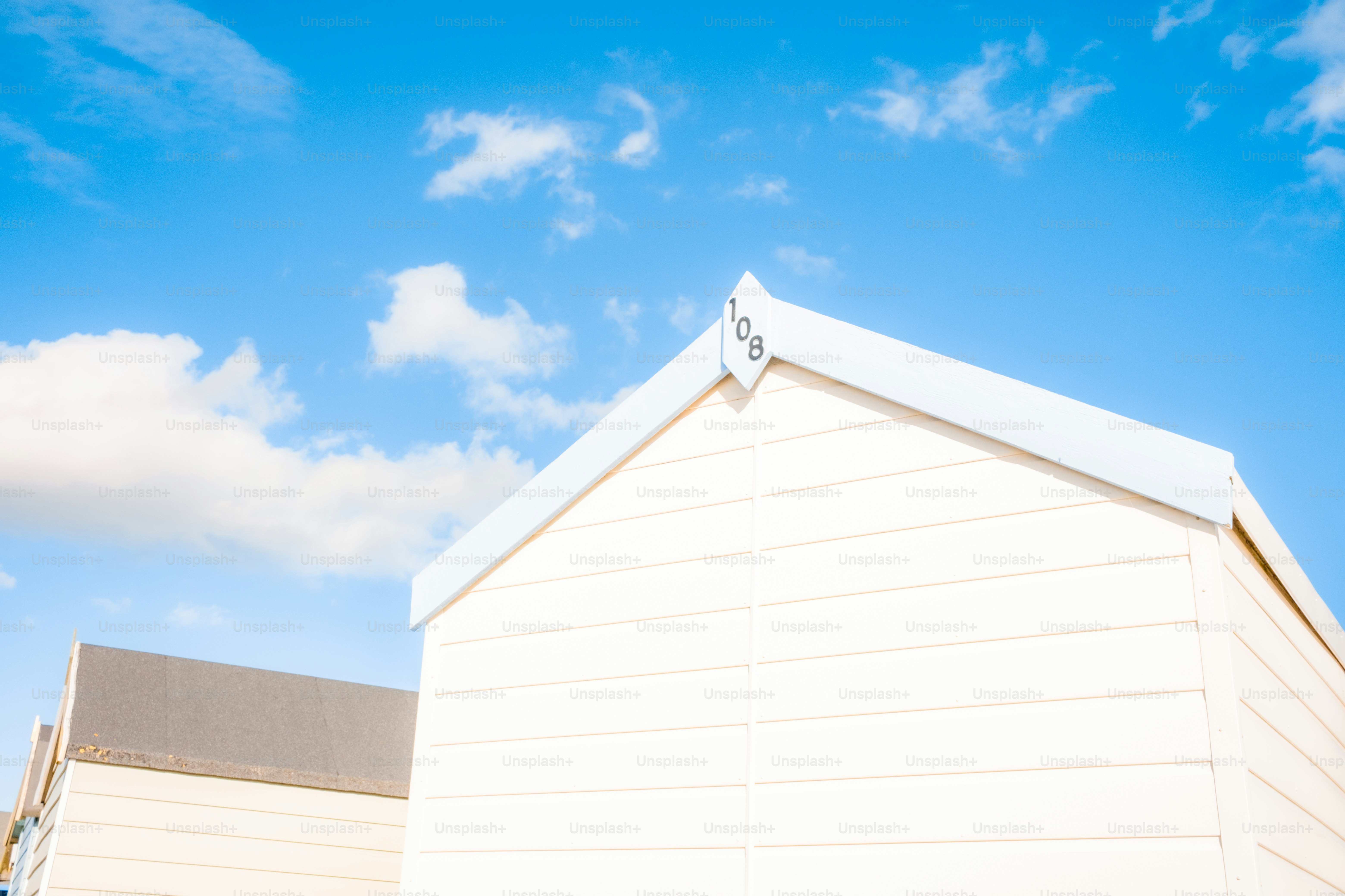 Three colorful beach huts under a blue sky. photo – Beach Image on Unsplash