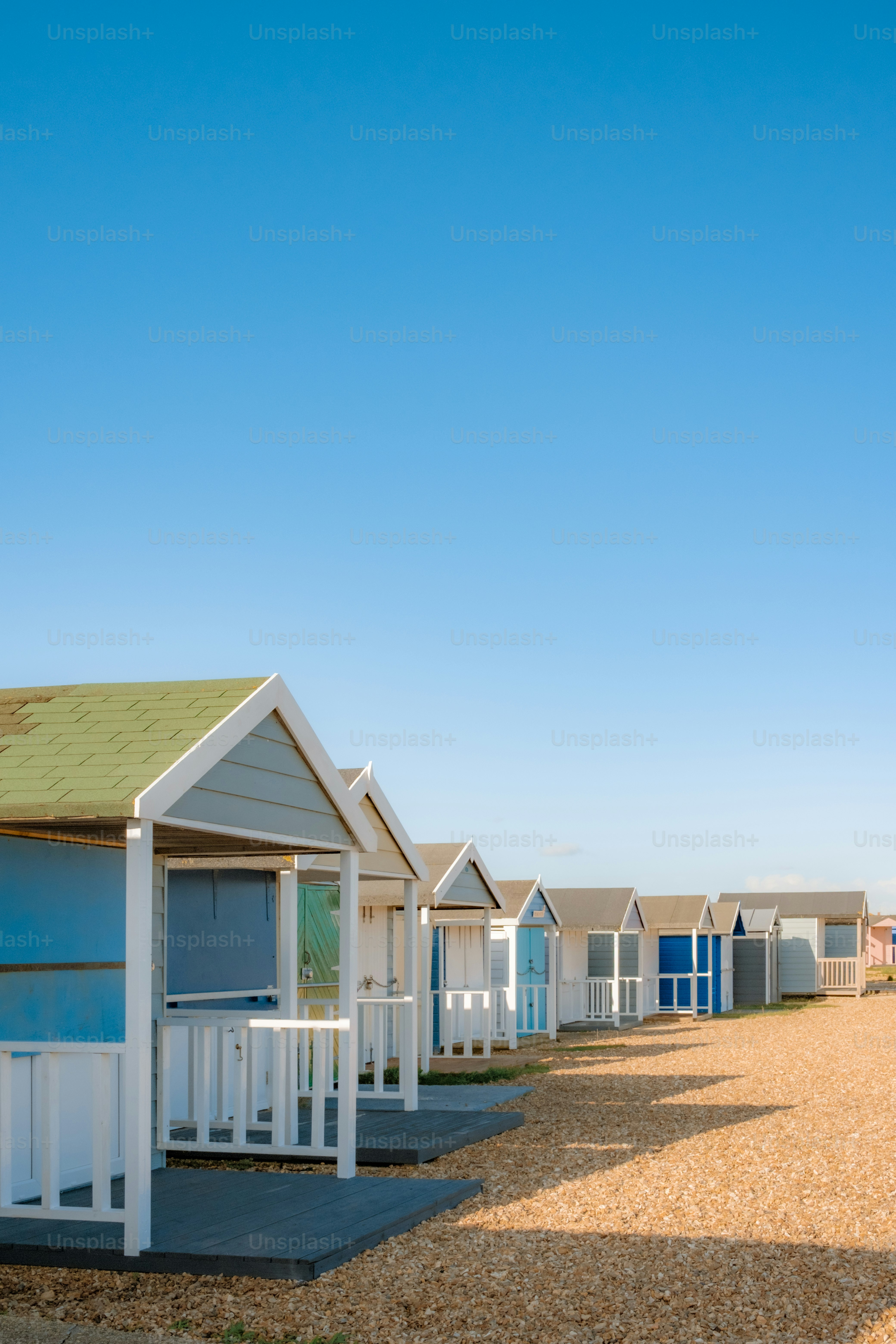 Colorful beach huts lined up on a sunny day. photo – Beach Image on ...