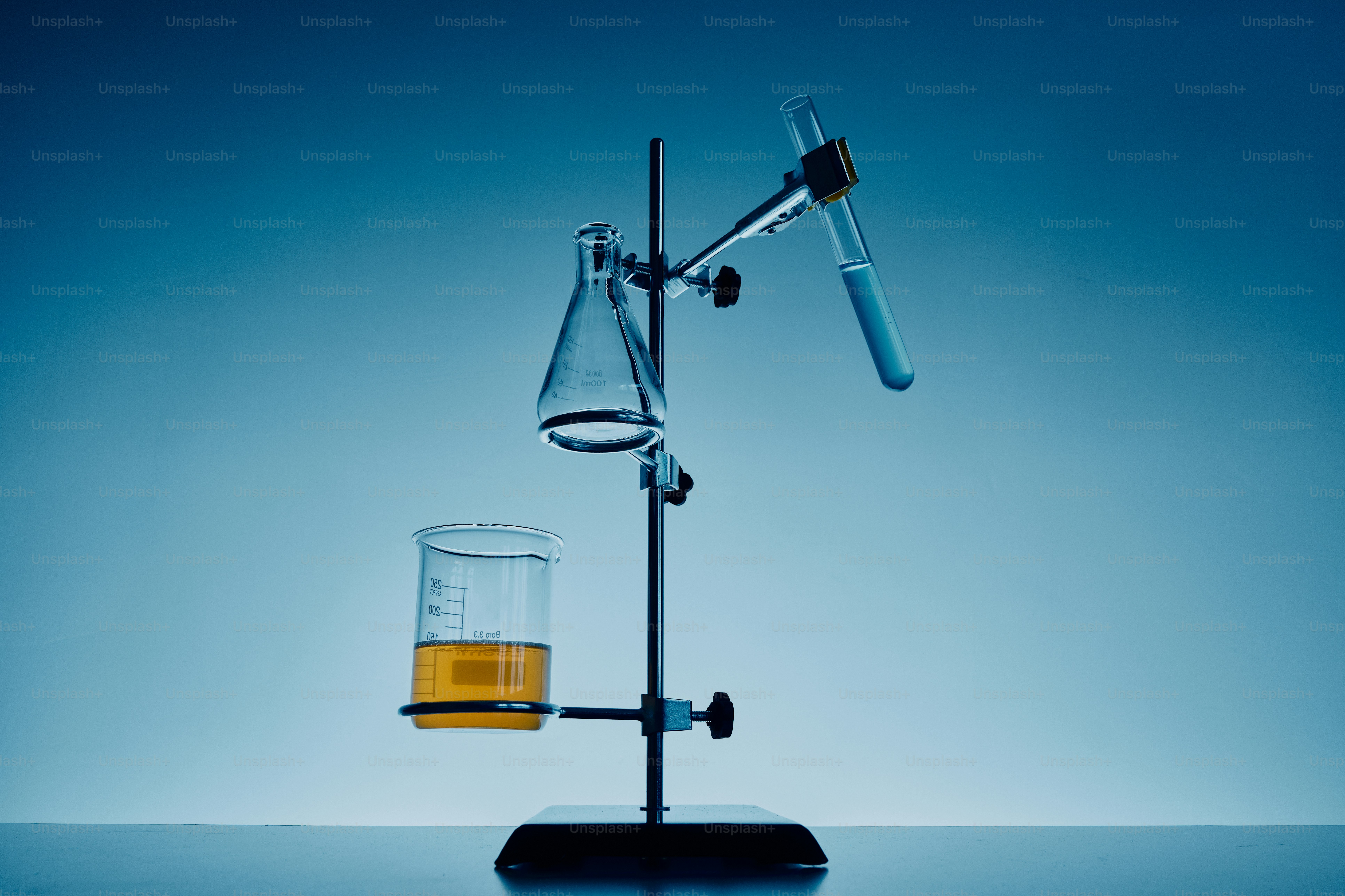 Laboratory equipment with liquids on blue background photo – Science ...