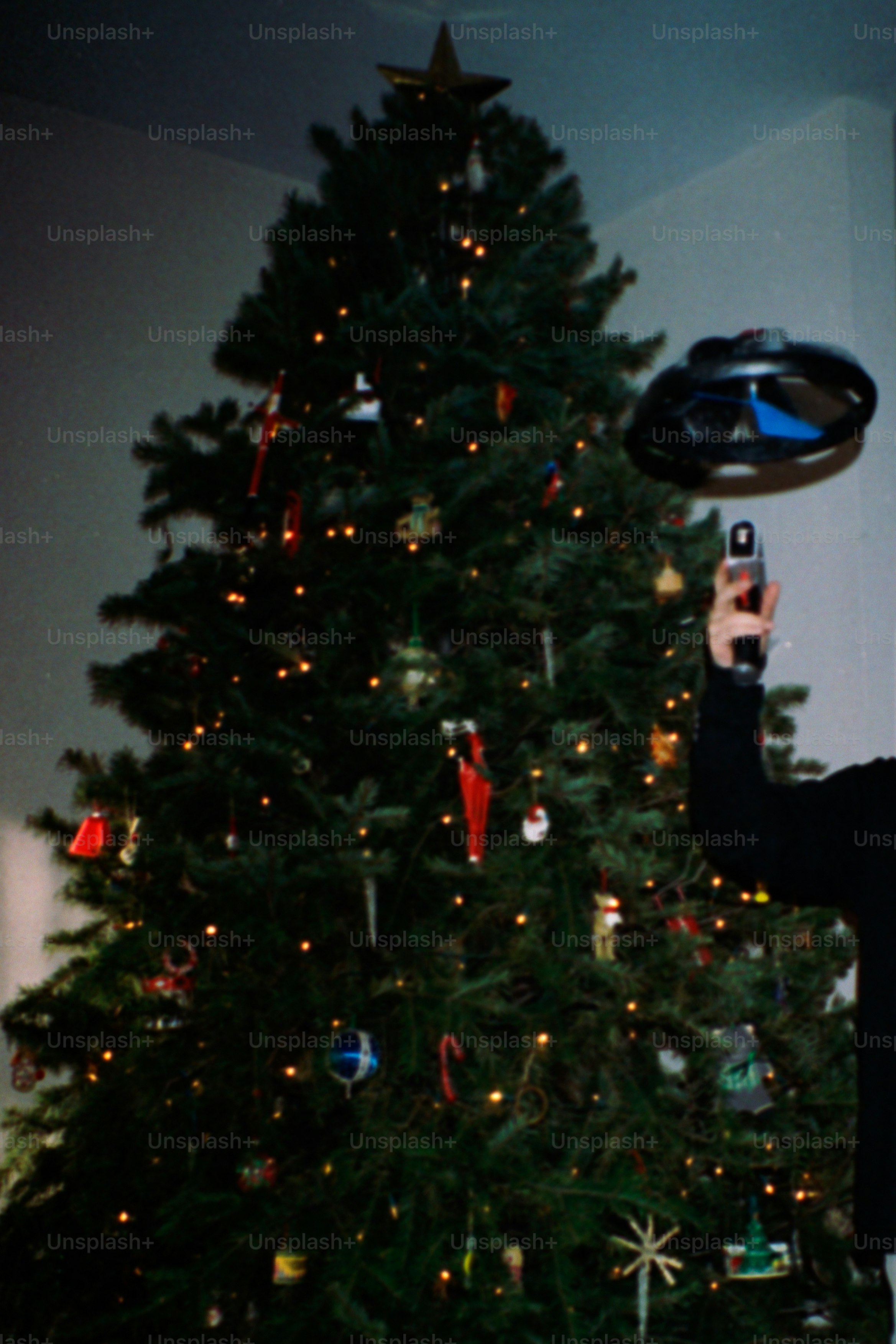 Person holding vr headset near decorated christmas tree. photo ...
