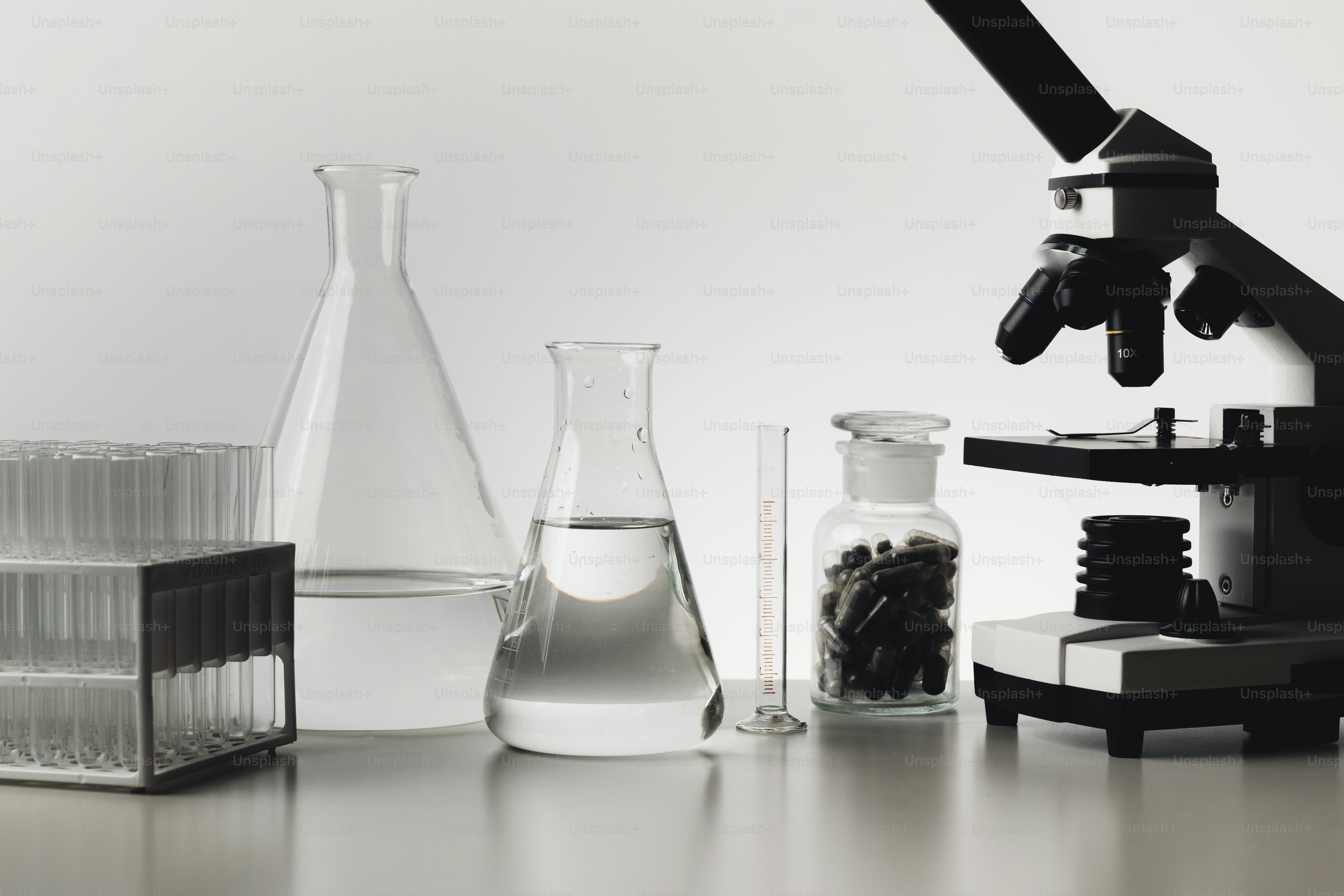 Microscope and laboratory glassware on a table. photo – Science Image ...